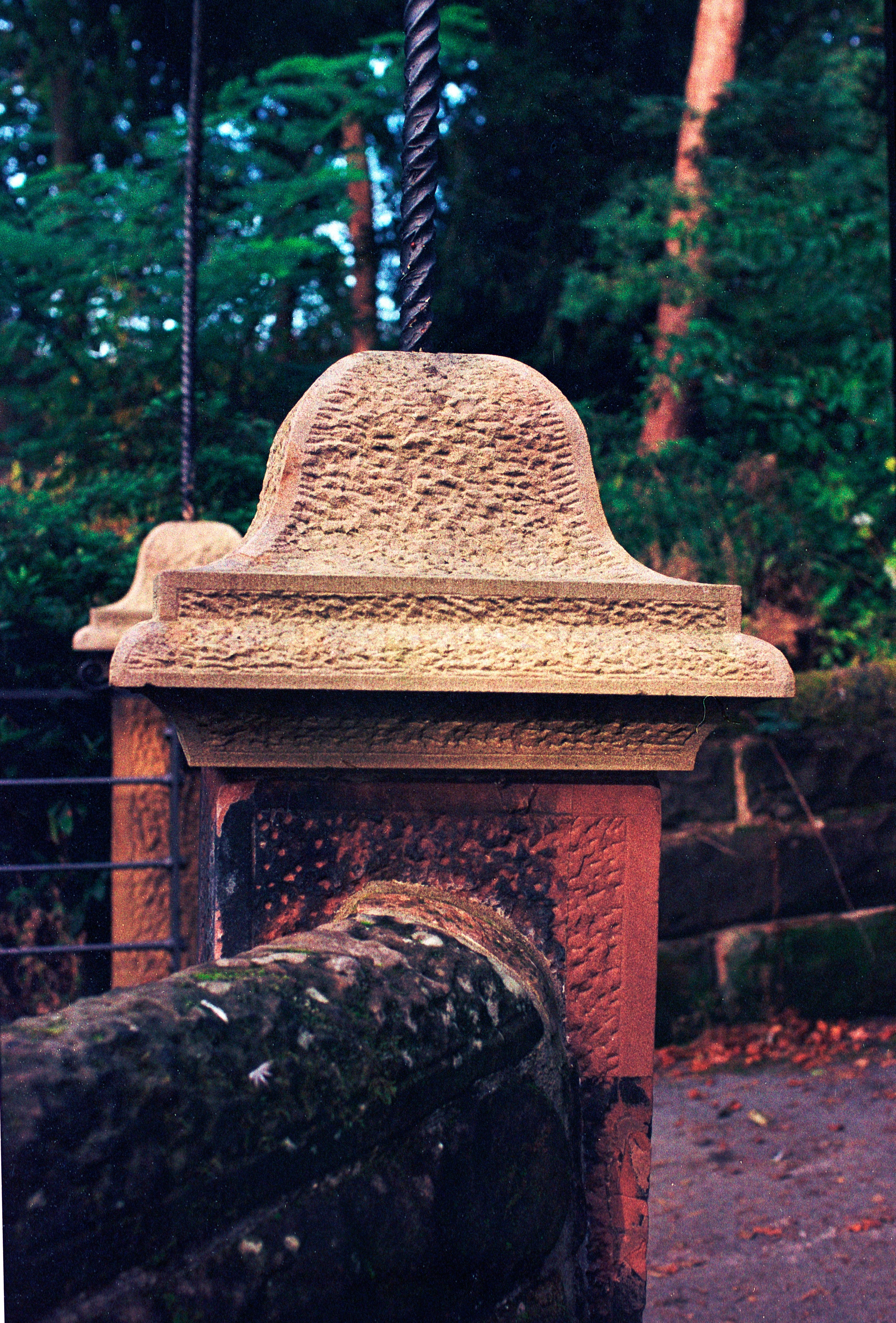 Weathered stone railing cap resting above a mossy balustrade