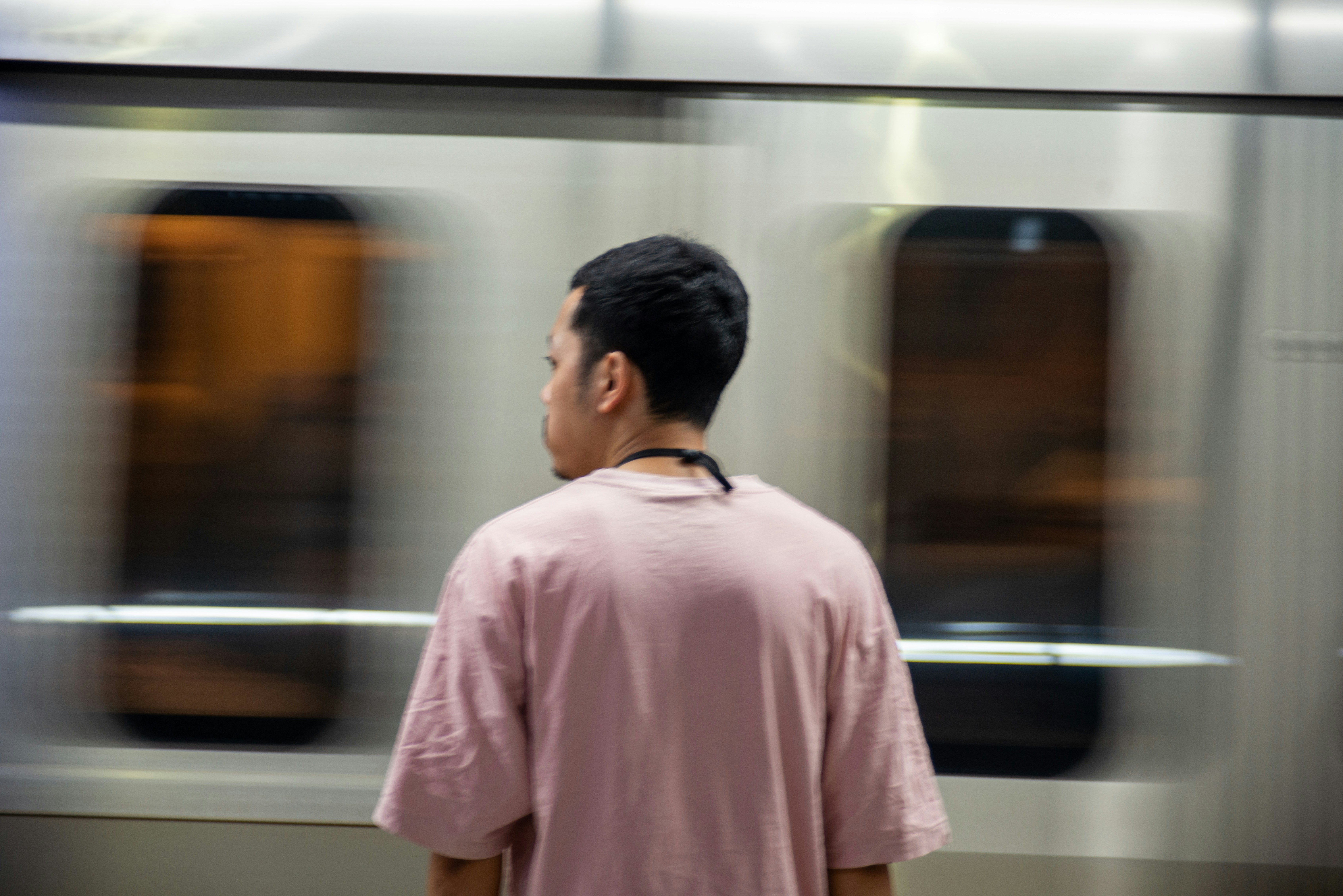 Paused in Motion: The Back of a Passenger as a Subway Rushes By