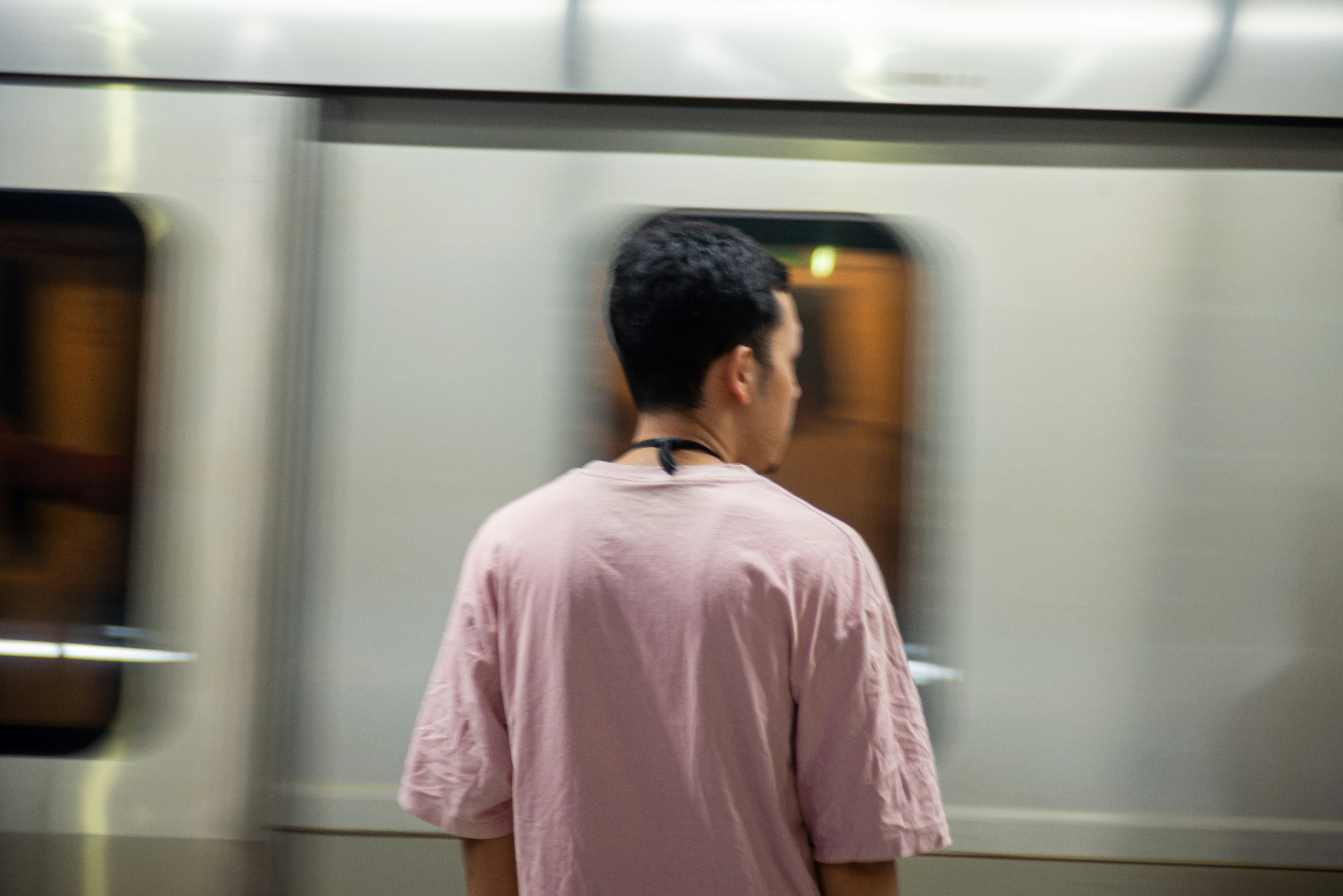 Pink Shirt in Transit: A Subterranean Portrait Amid Motion