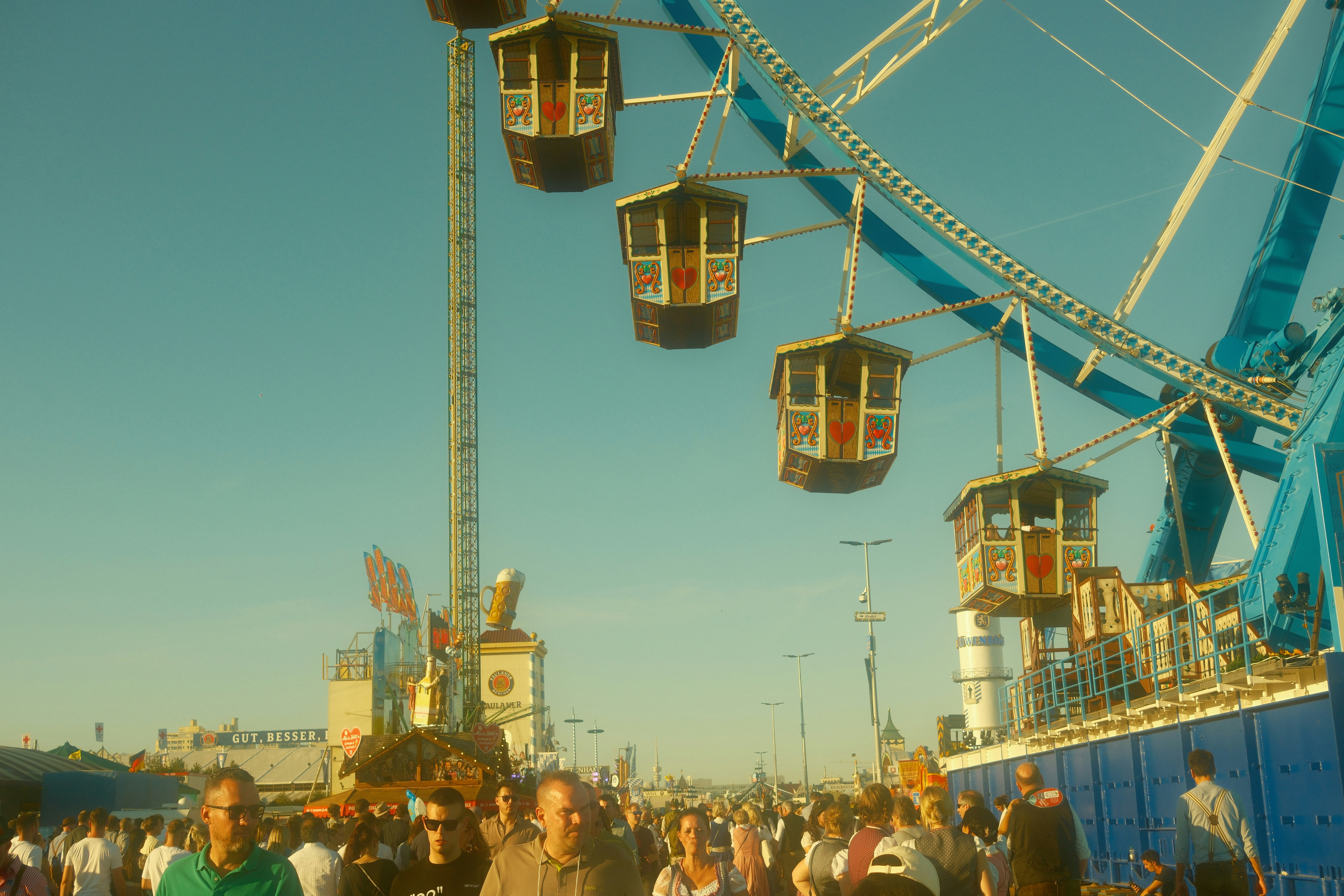 Sunlit Ferris Wheel Rises Above a Bustling Seaside Carnival