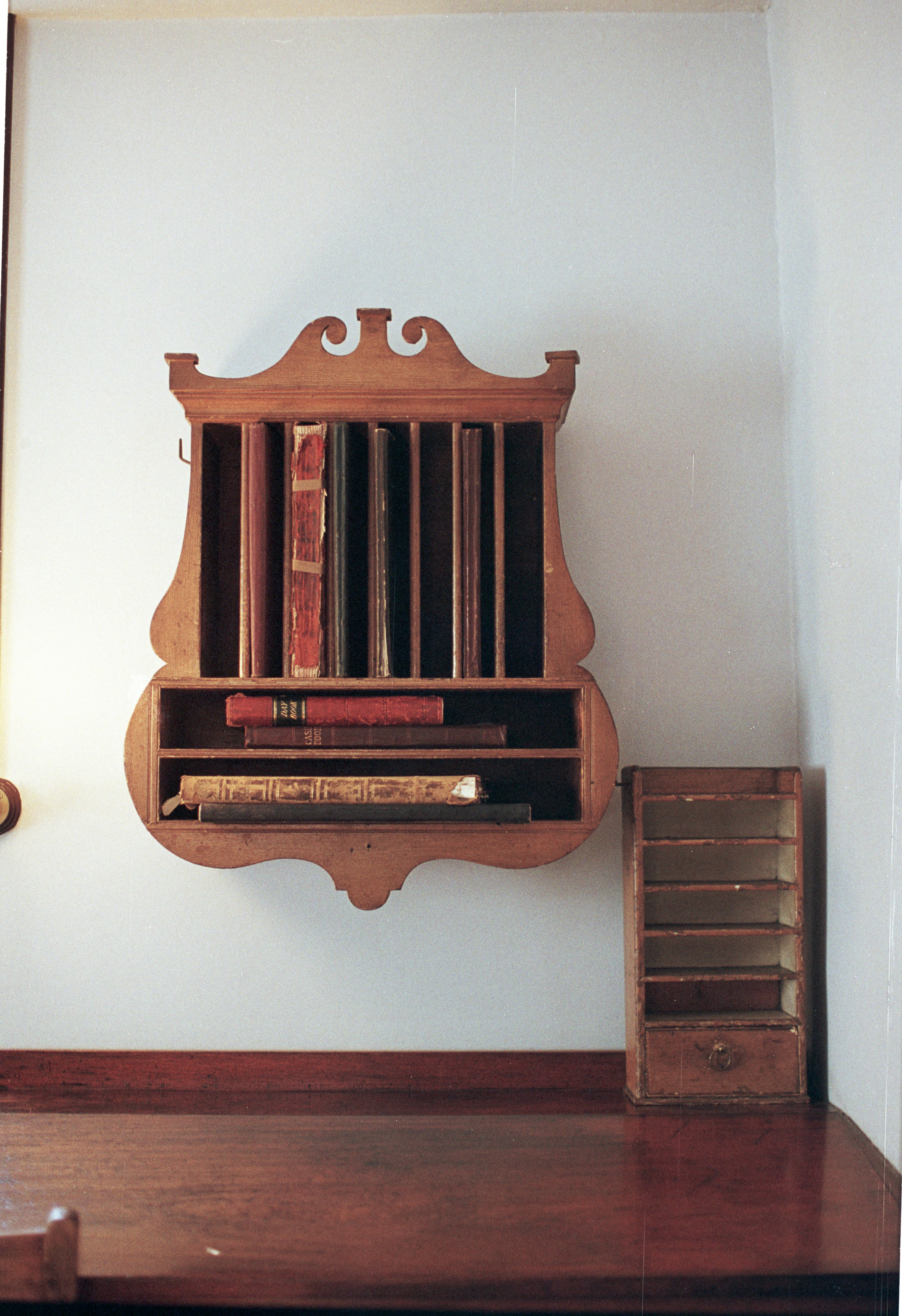Antique wooden wall organizer with books