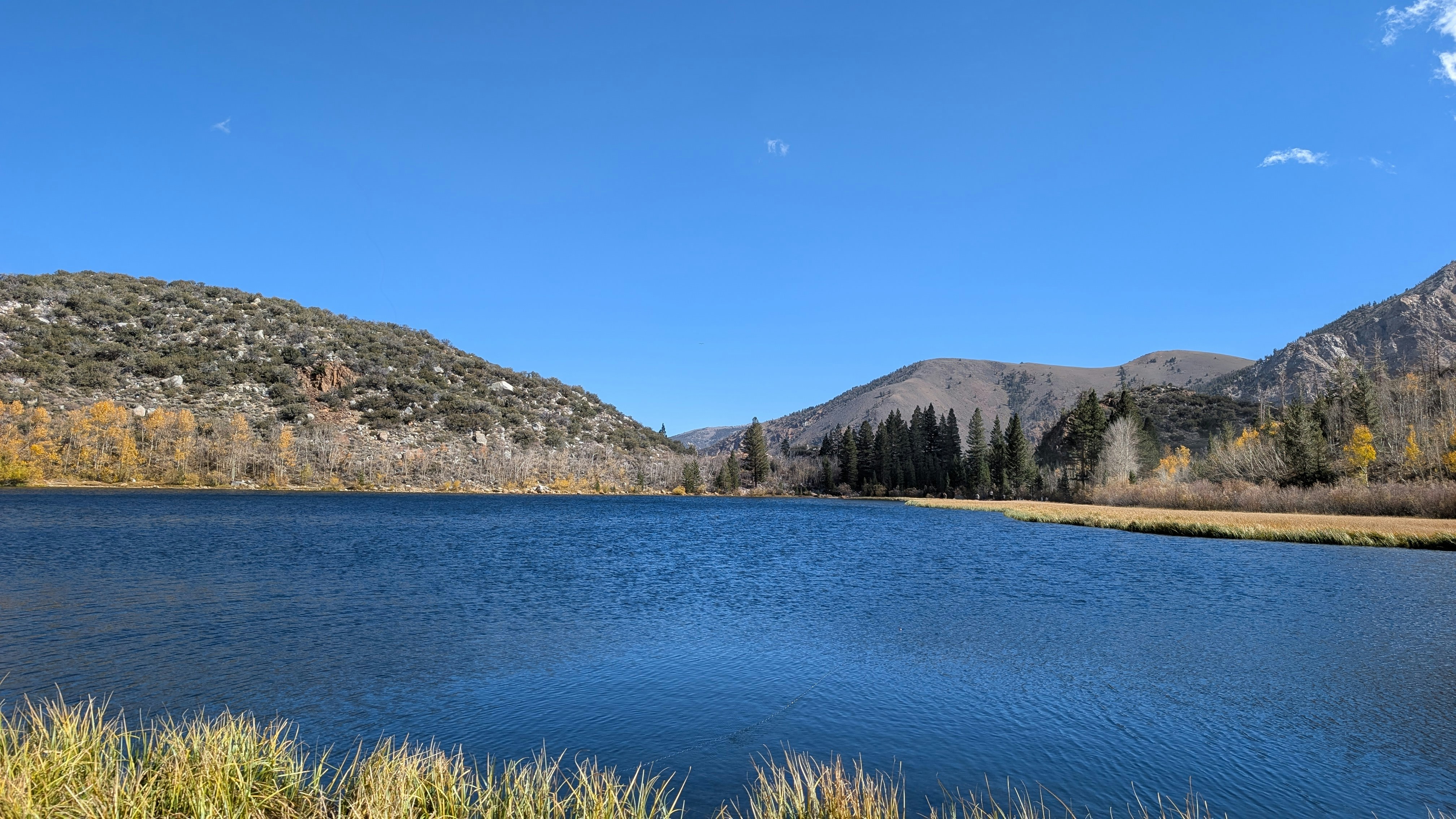 Blue lake surrounded by hills under a clear sky