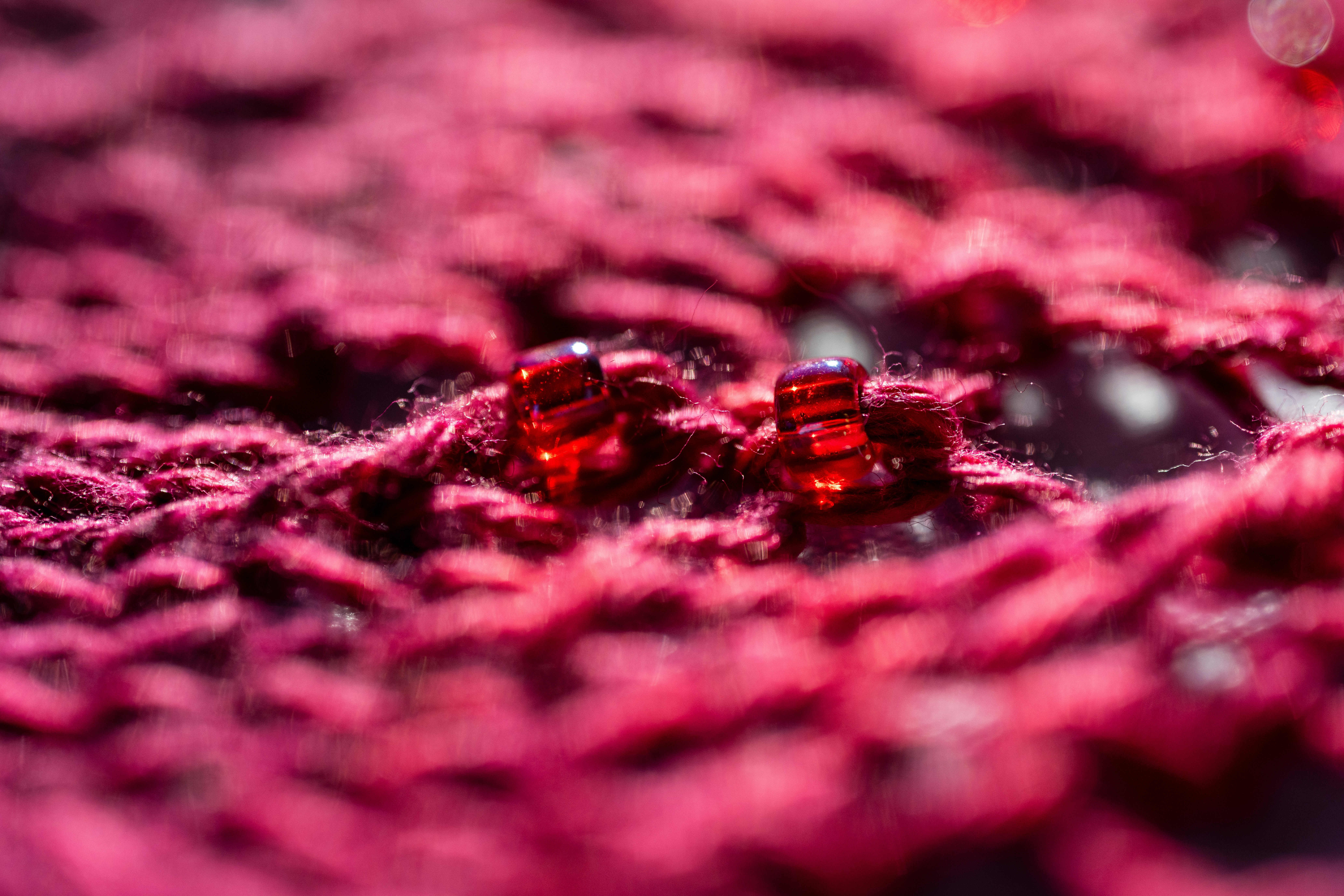 Two red beads on a textured red surface