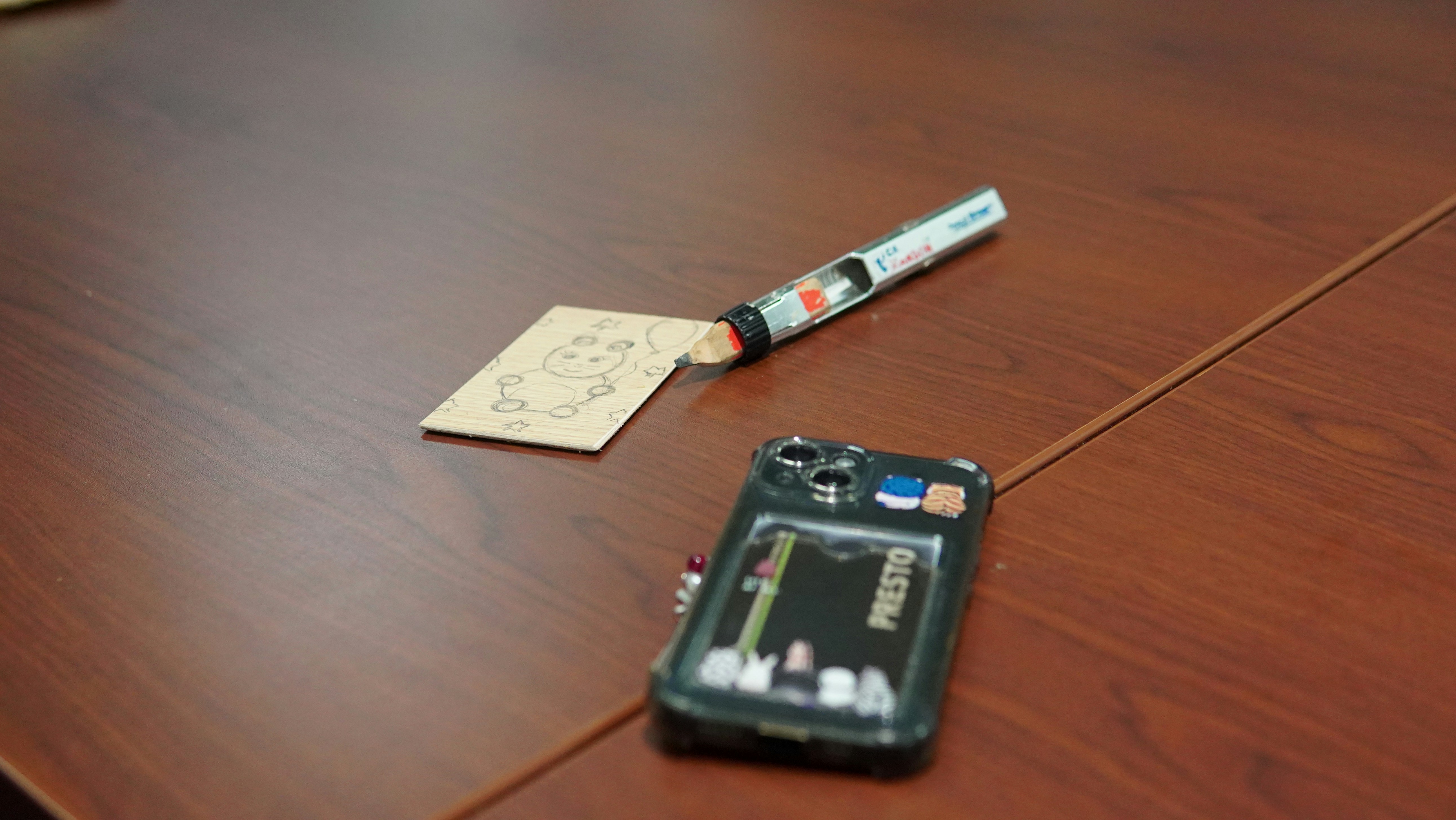 A pen and a disassembled phone on a wooden table