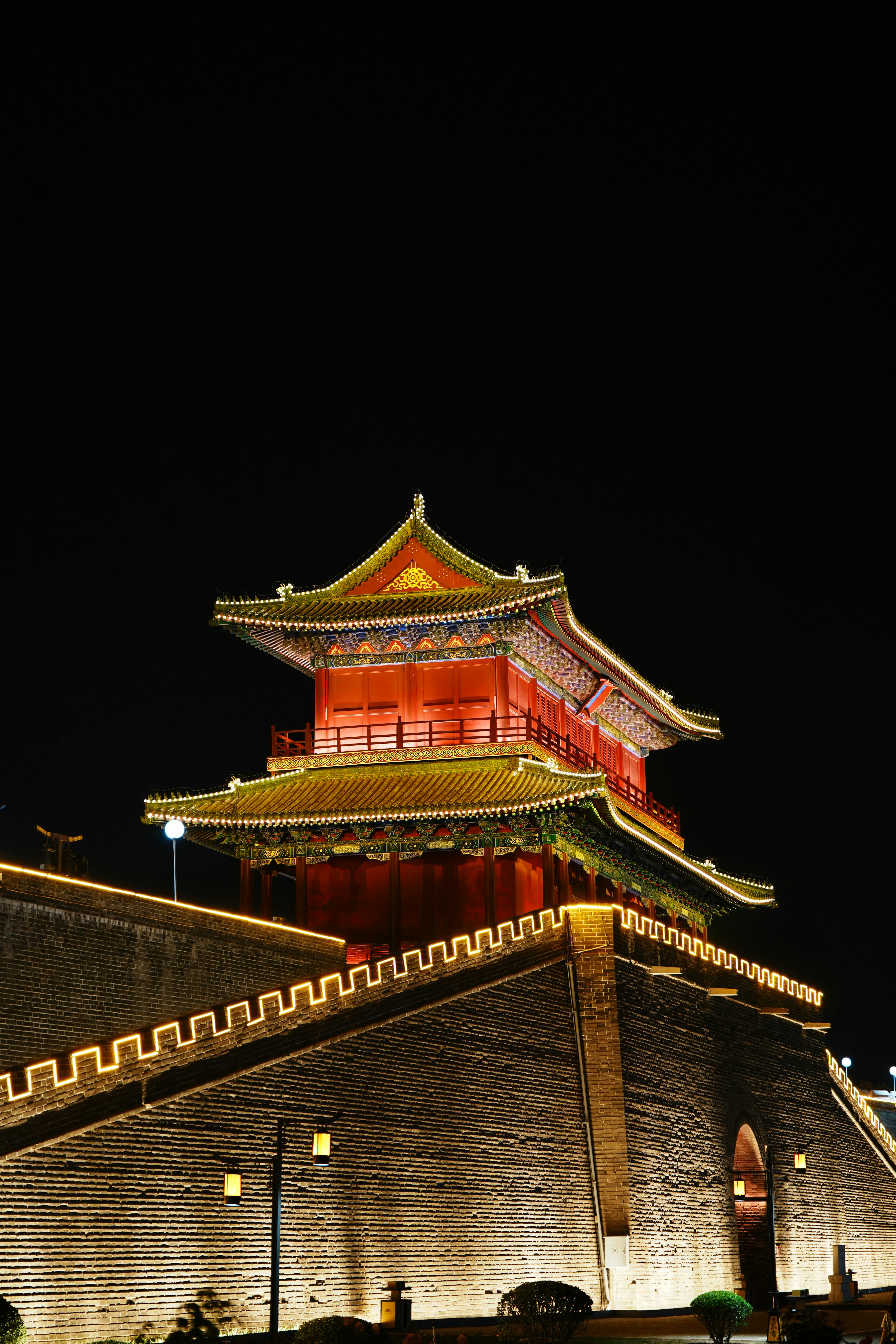 Illuminated ancient chinese tower and wall at night.