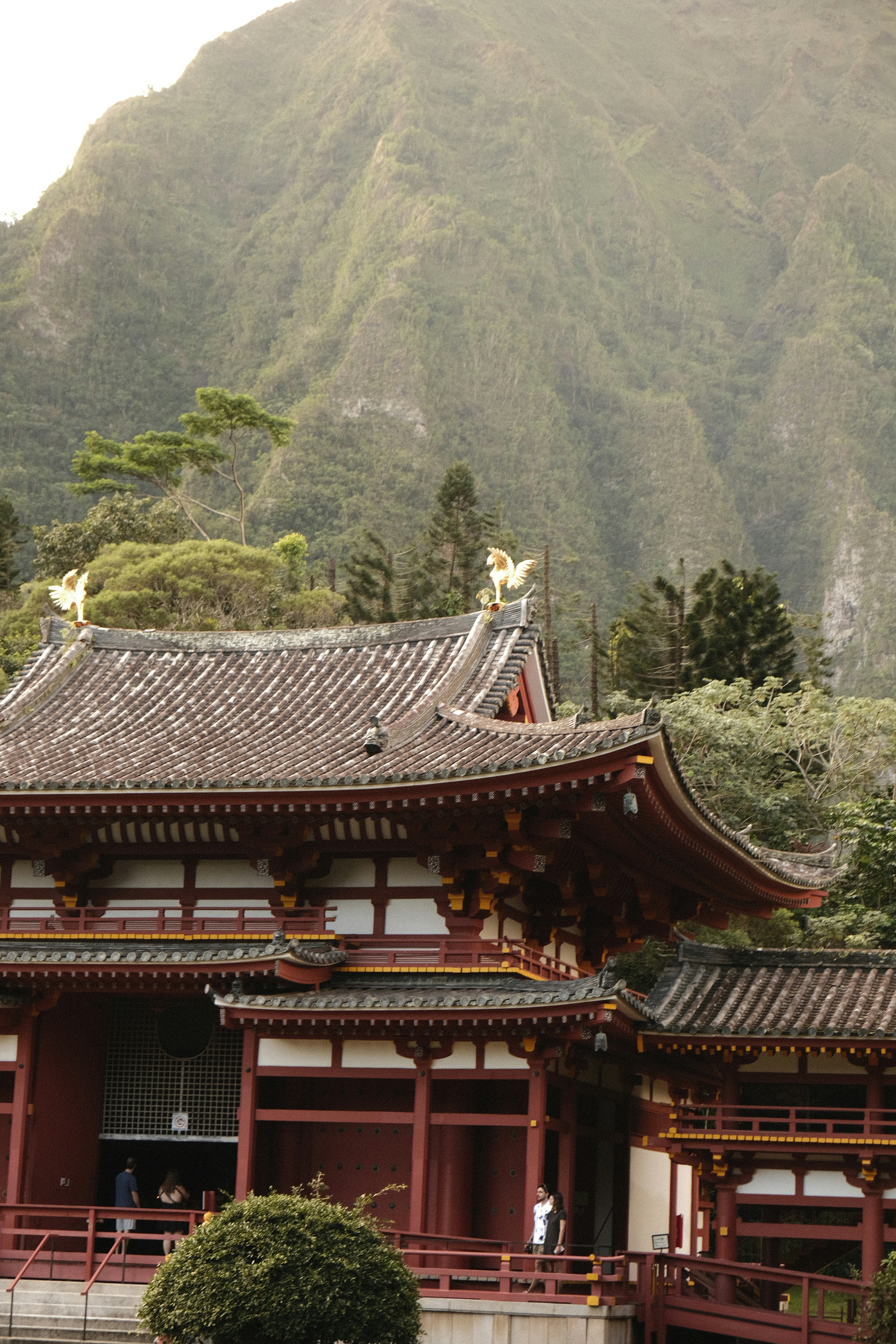 Traditional Japanese temple nestled against a backdrop of lush mountains, highlighting architectural elegance and serene landscape.