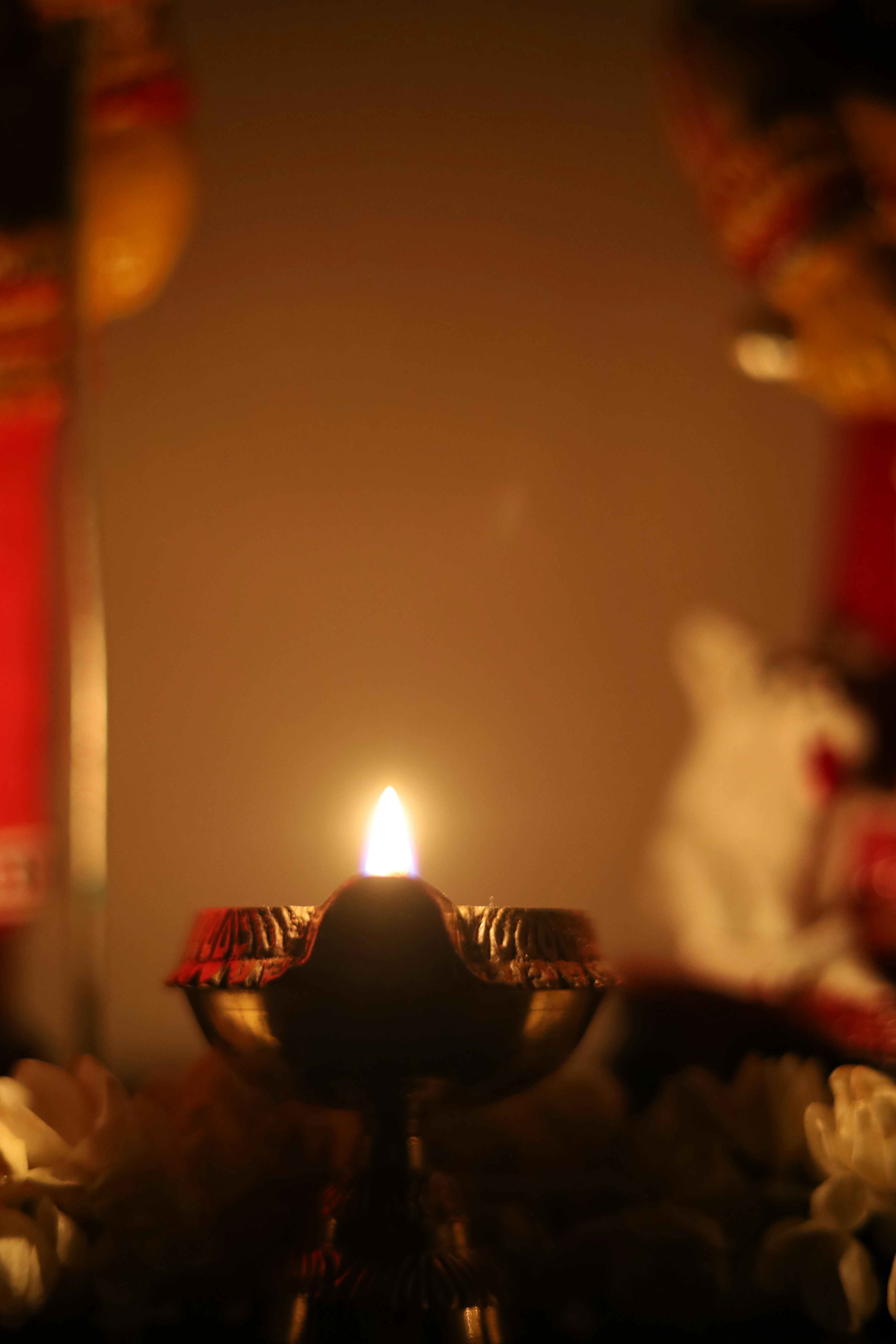 A lit oil lamp in a dimly lit room.