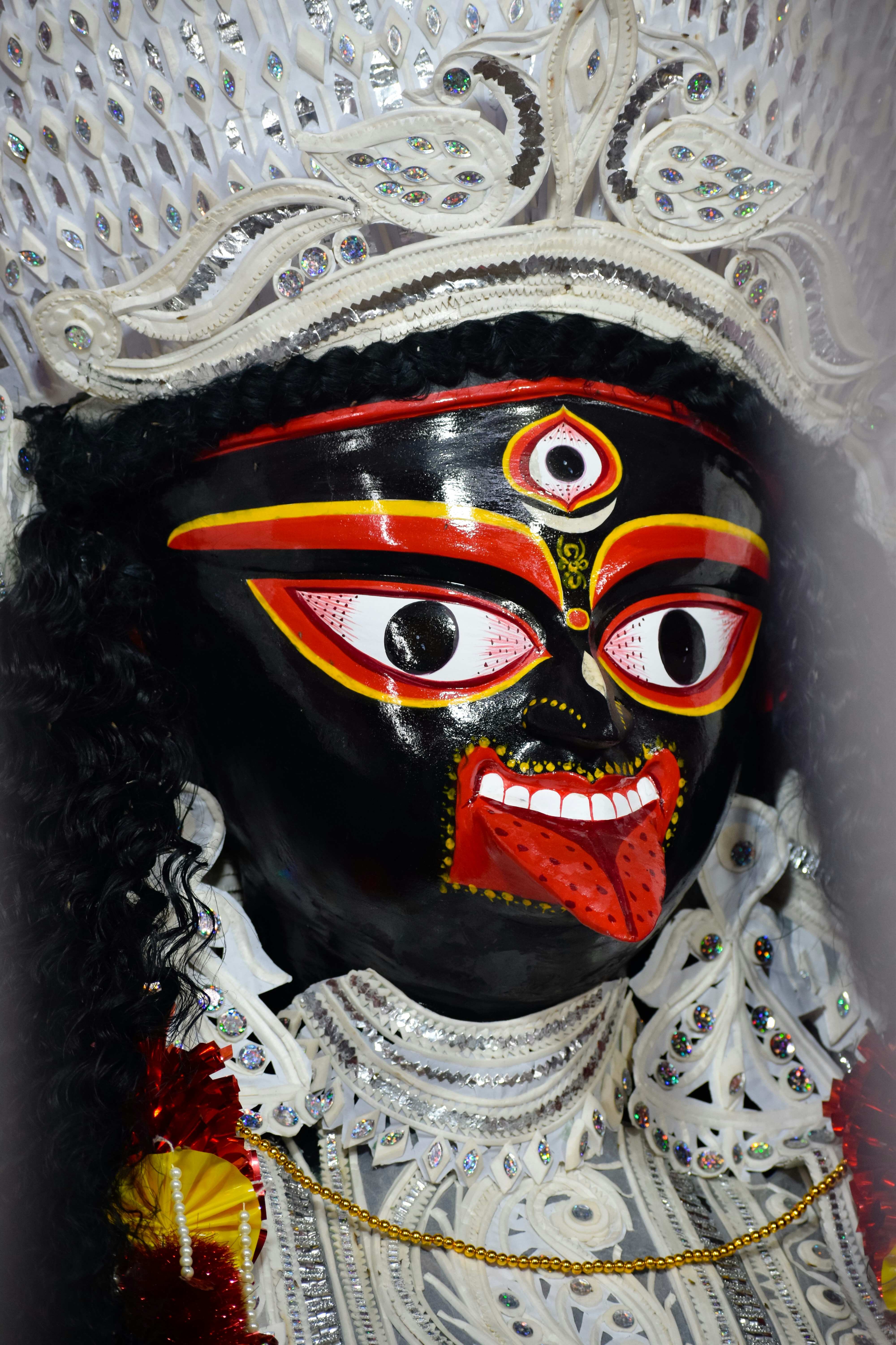 Vibrant depiction of a traditional deity with intricate detailing, showcasing a striking expression and elaborate adornments.