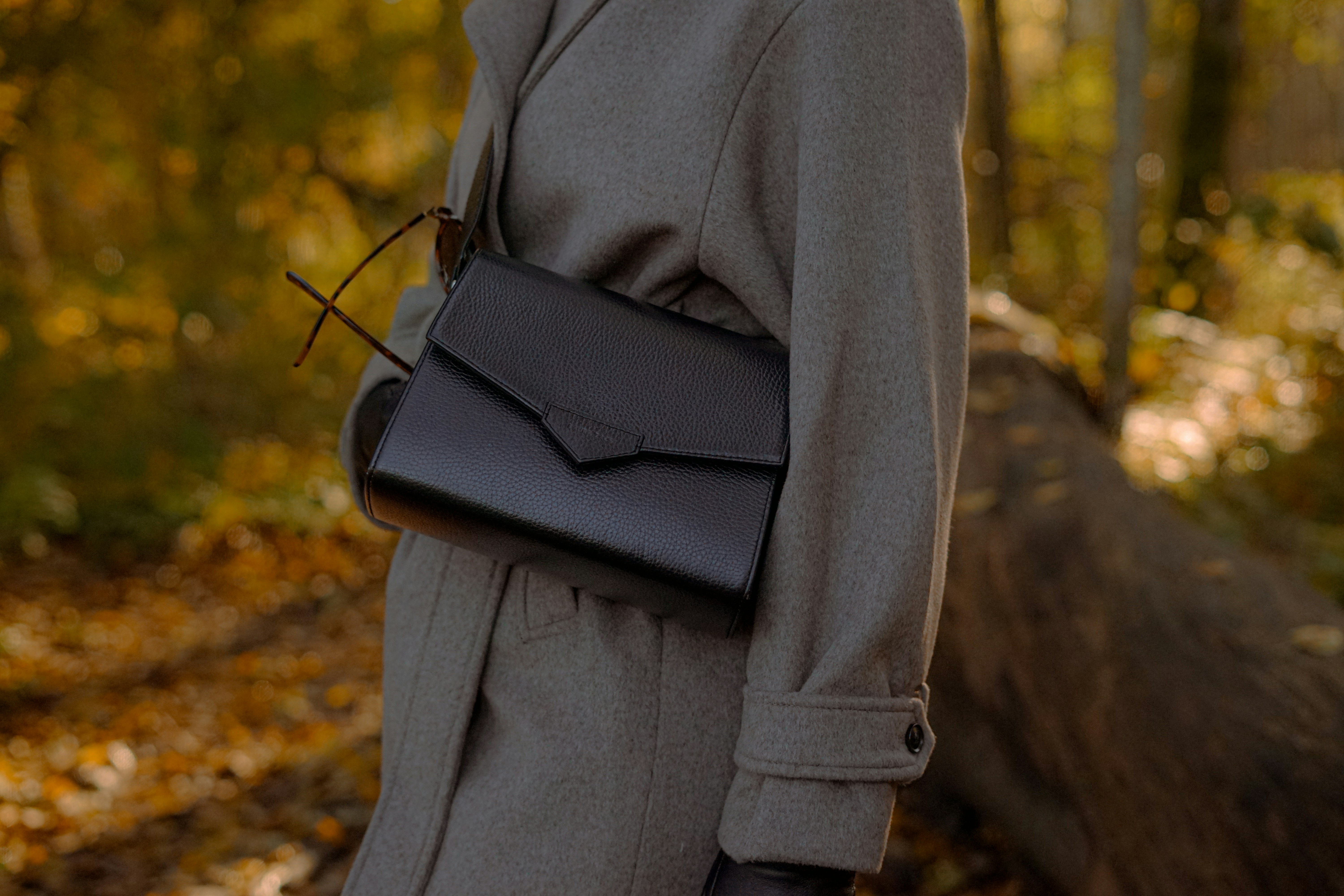 Minimalist elegance: a taupe coat and crossbody bag in autumn light
