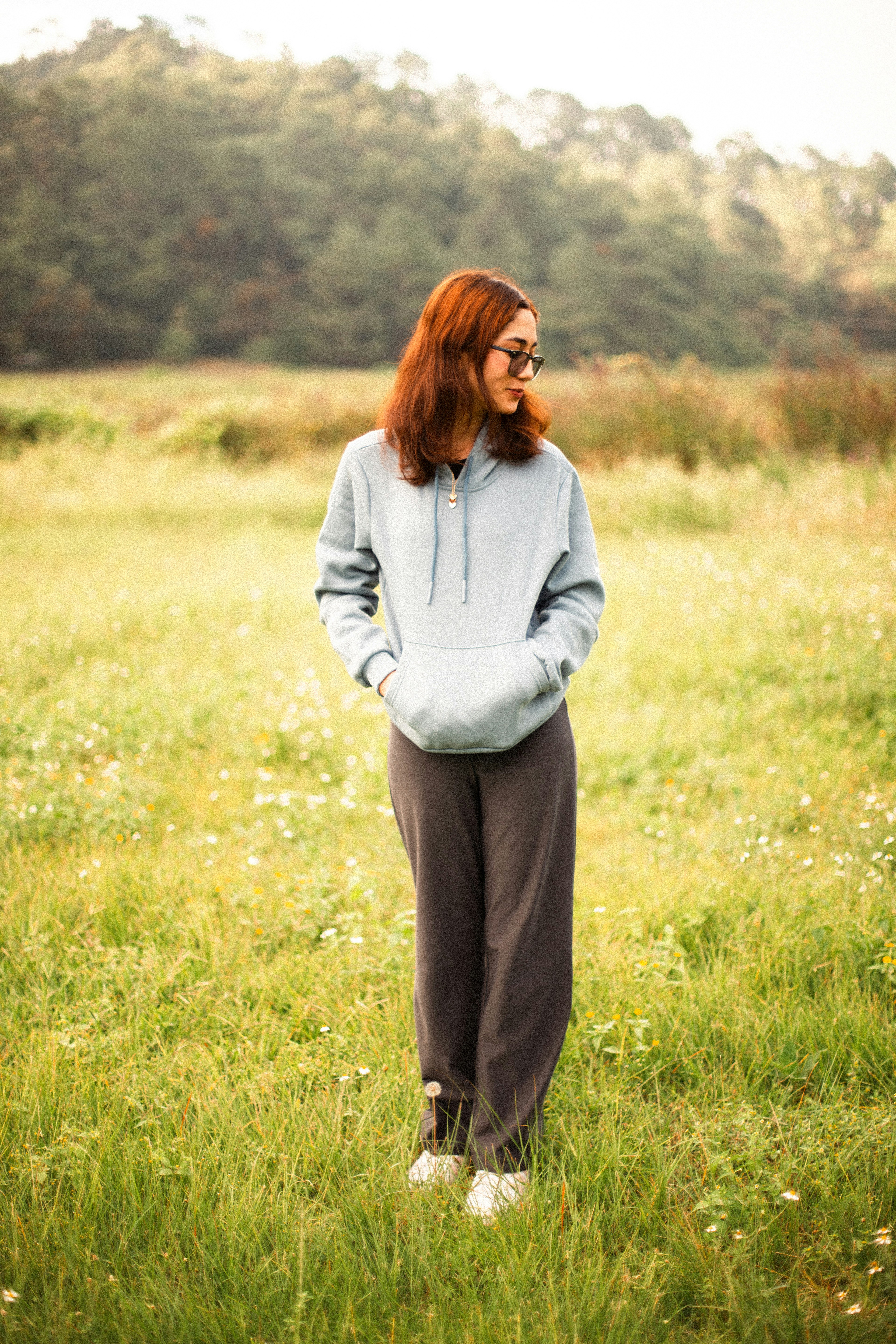Young woman stands in a grassy field