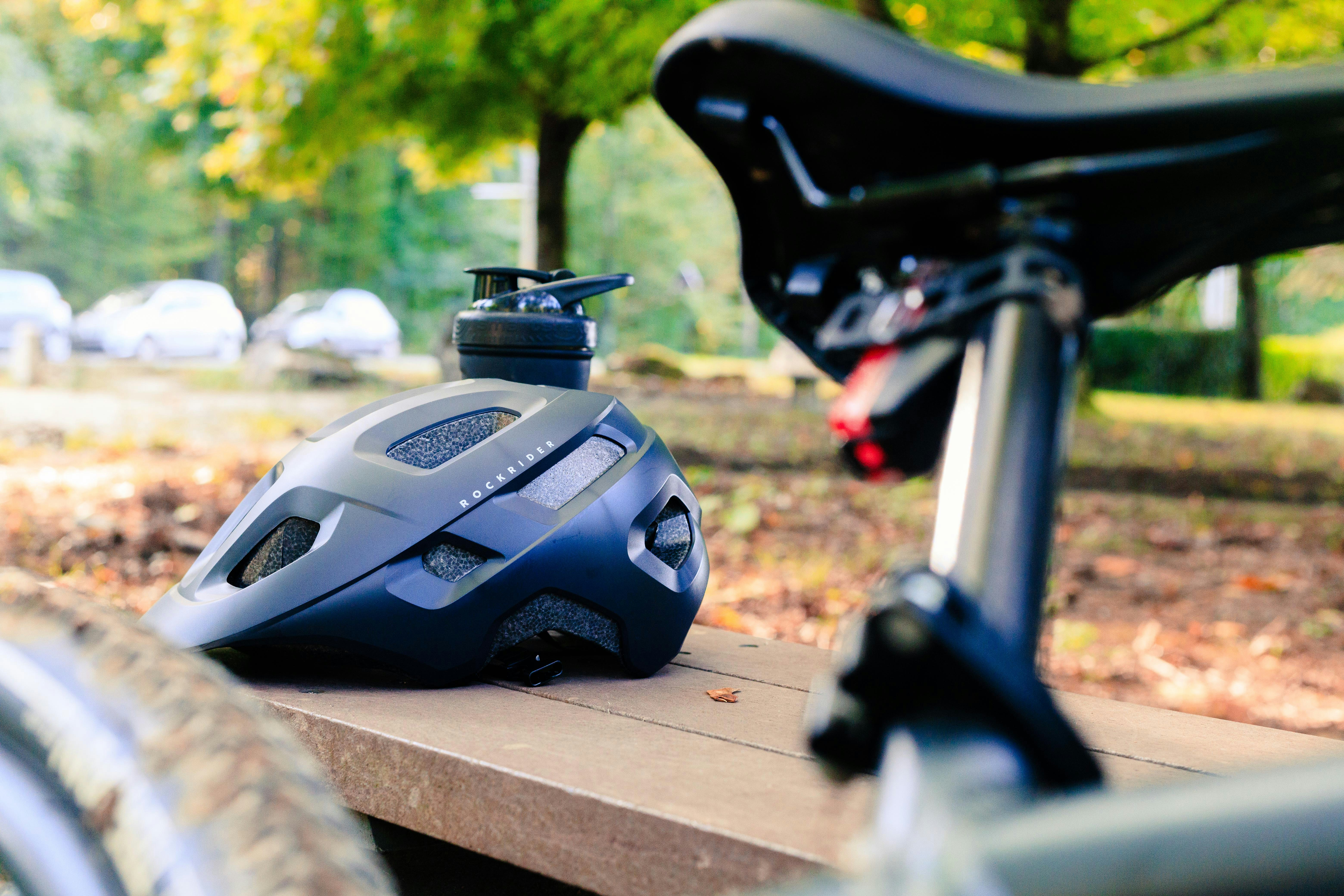 Bicycle helmet and water bottle on wooden bench