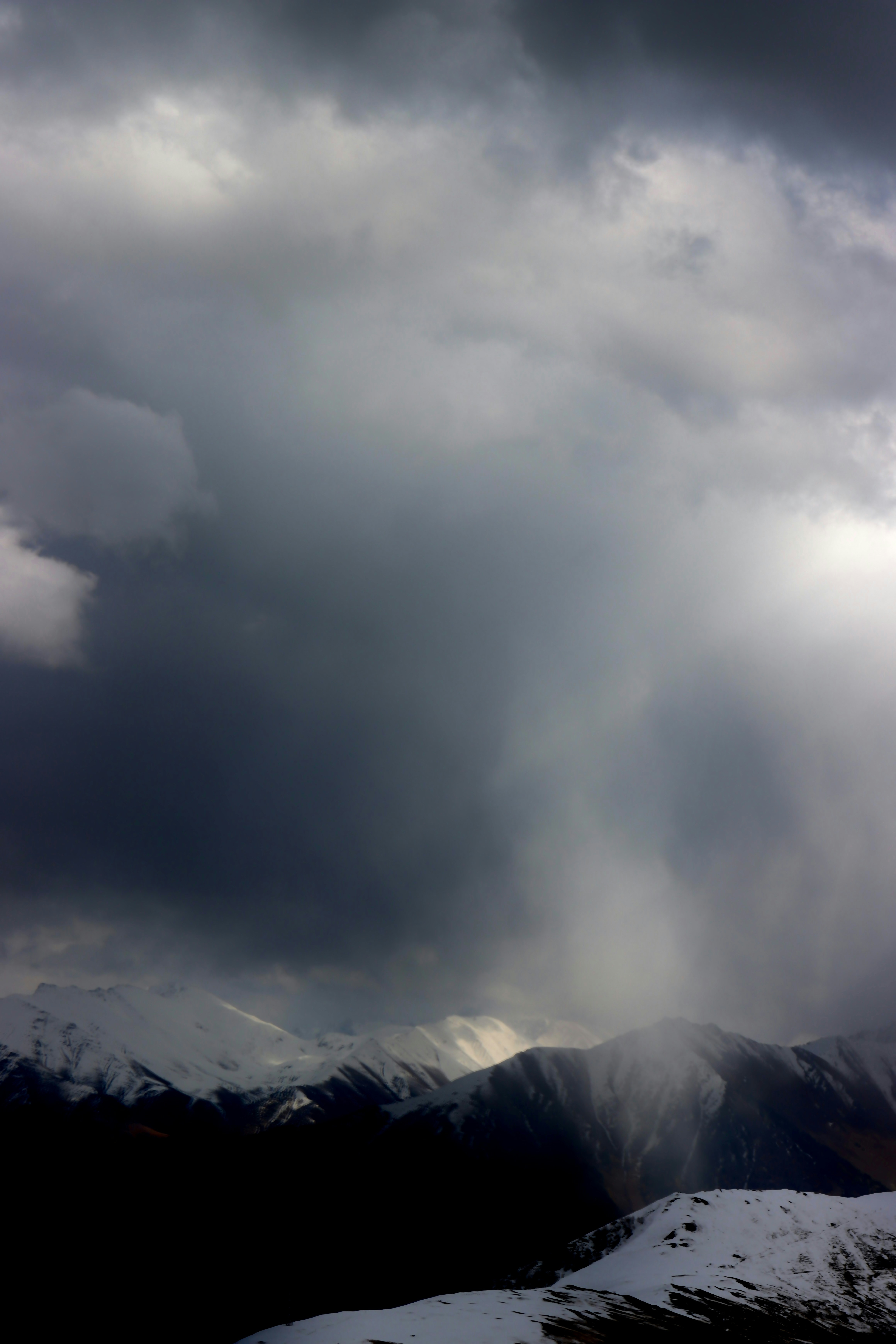 Veil of Clouds Over Majestic Peaks