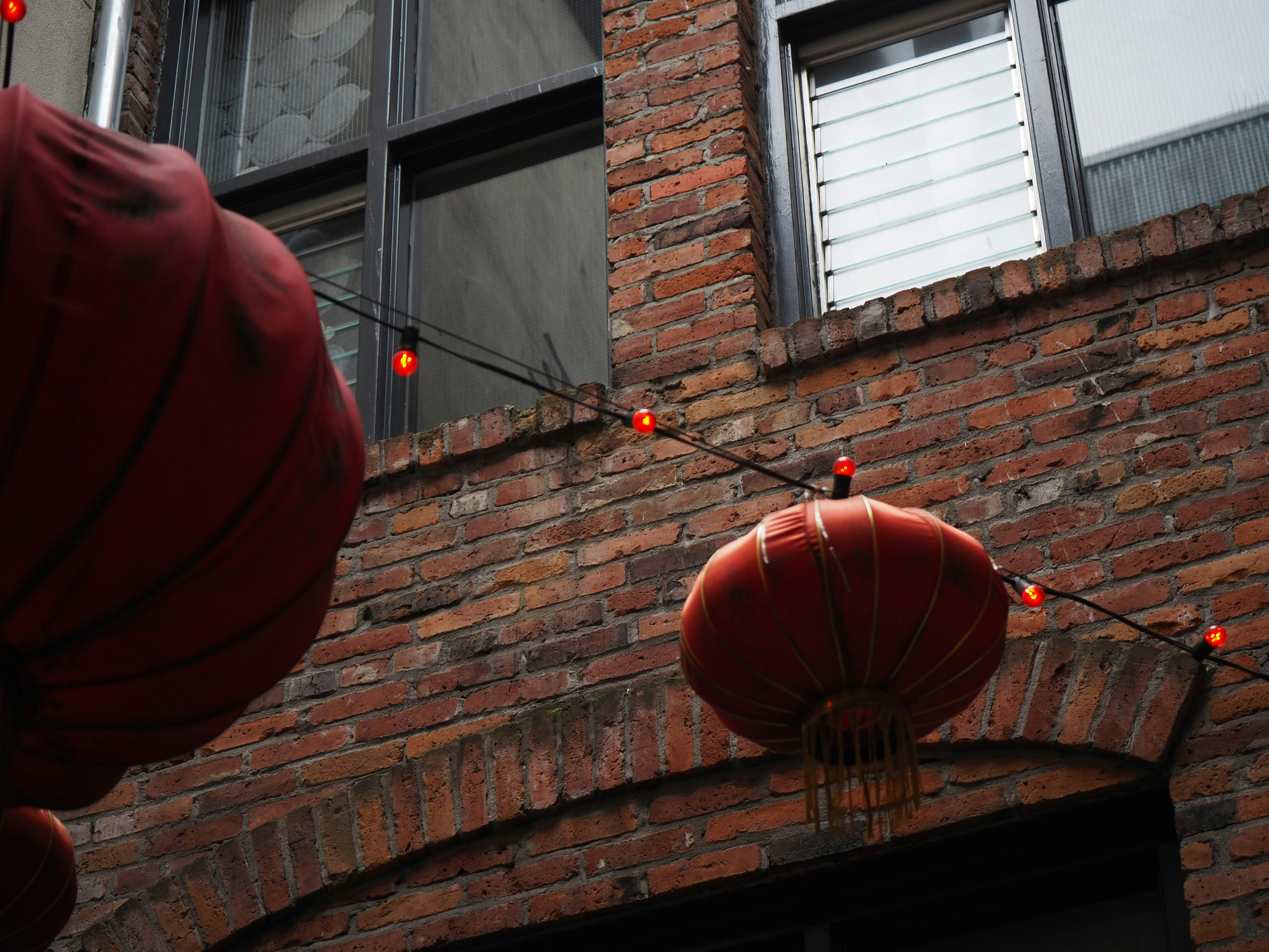 Whispers of Tradition: Lanterns Adorning Brick Facades
