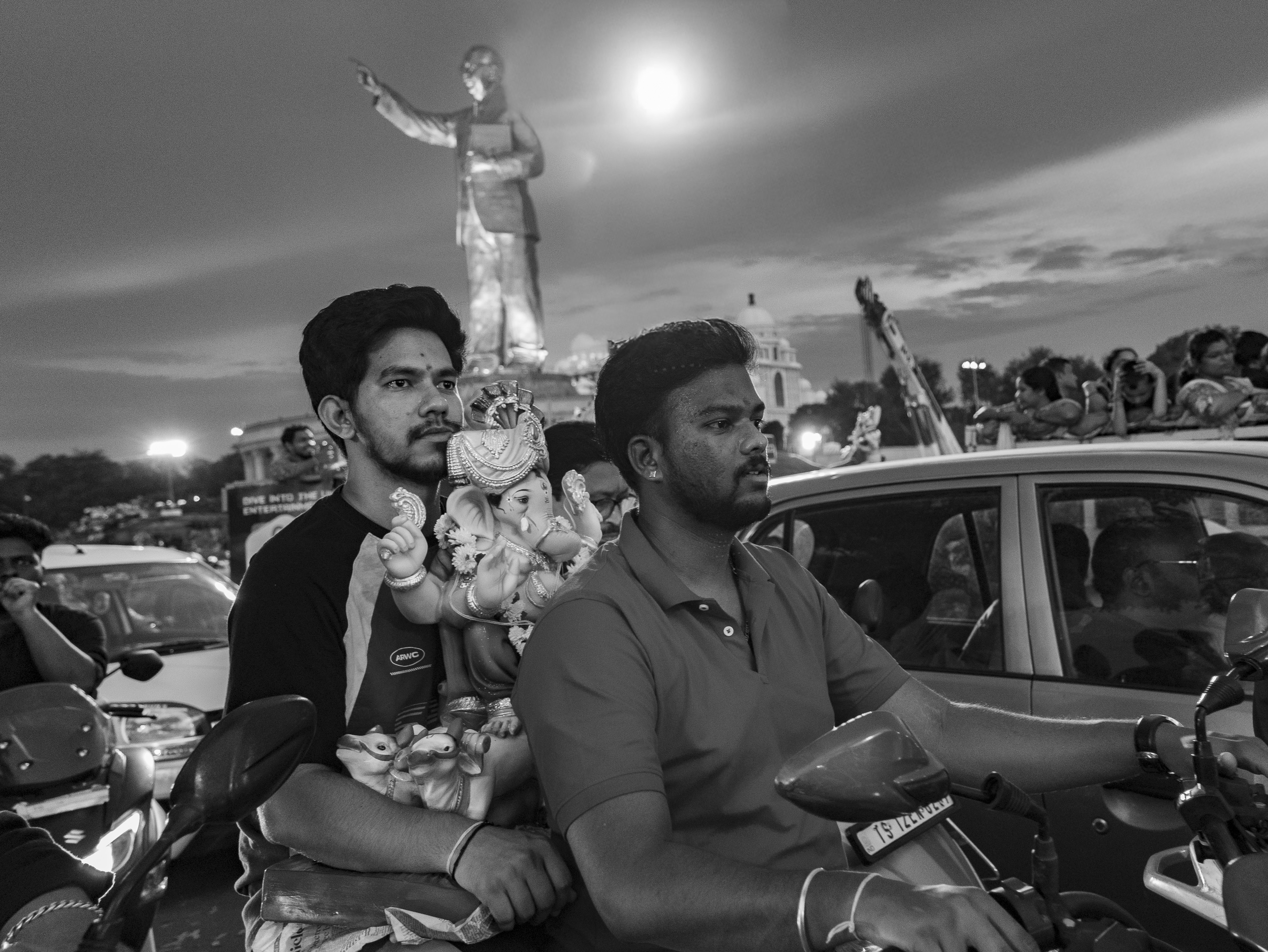Moto-Procession Through the Night: Hands, Faces, and a Statue