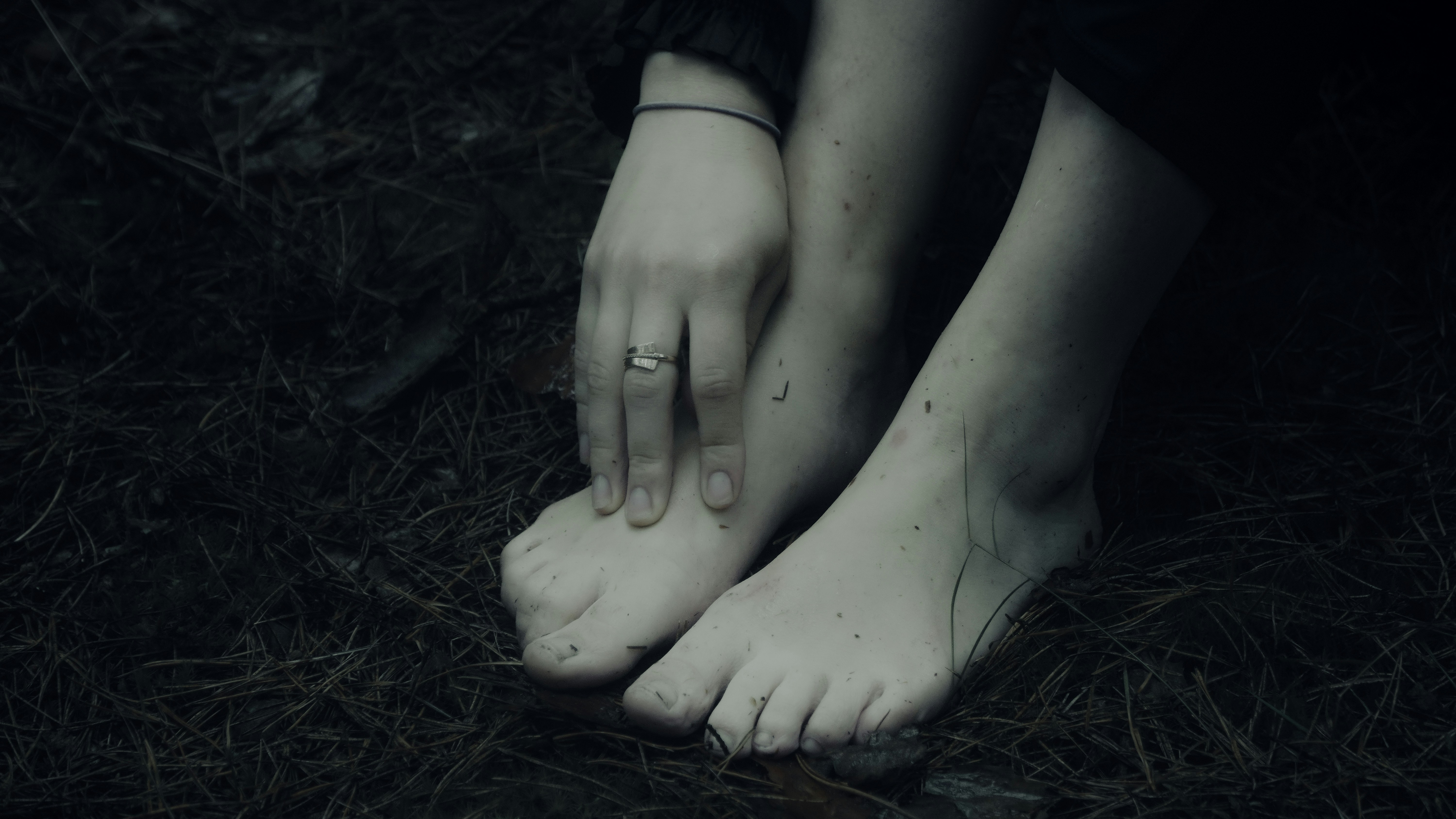 Bare feet with dirt and grass between toes.