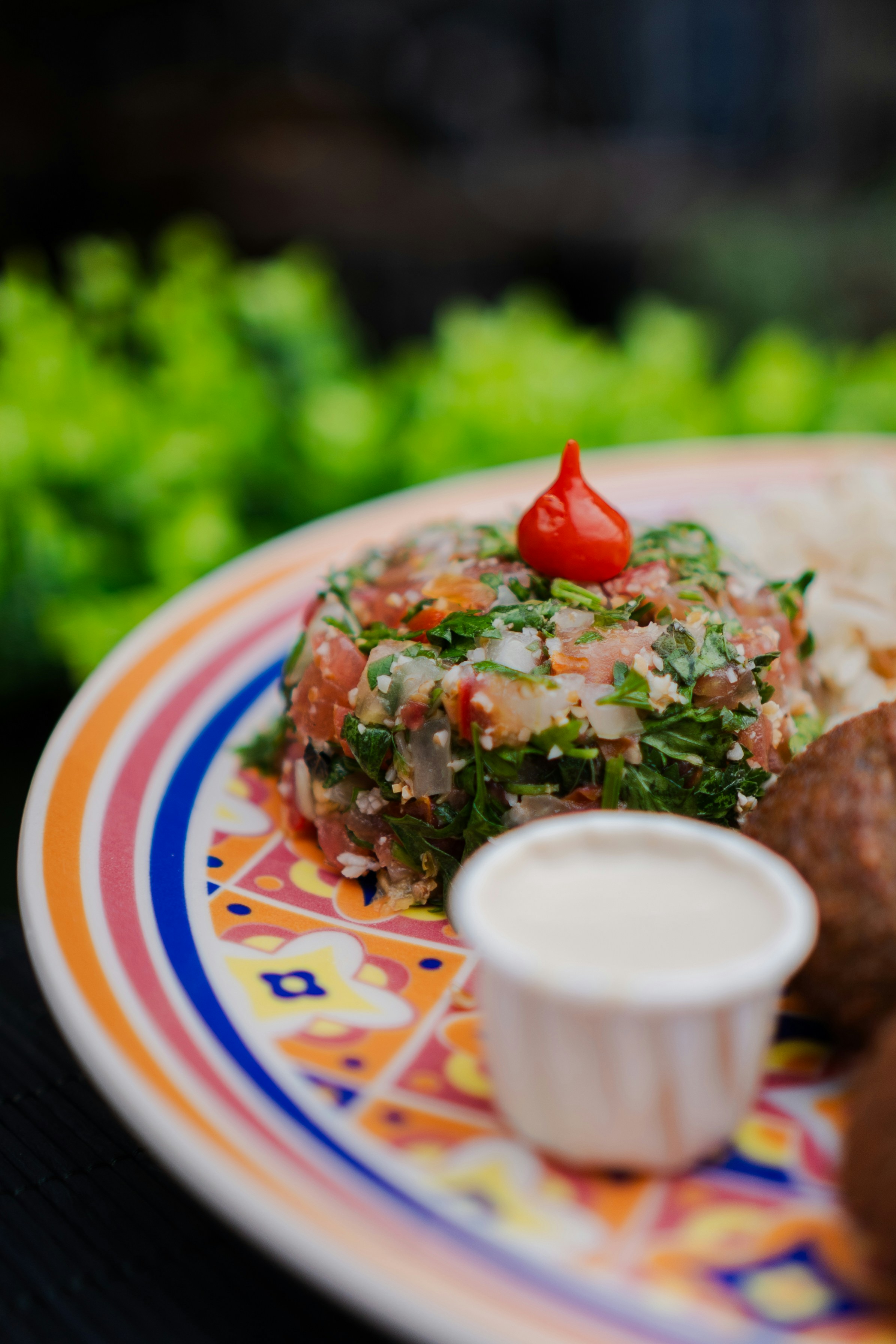 A colorful plate of food with a small red pepper.