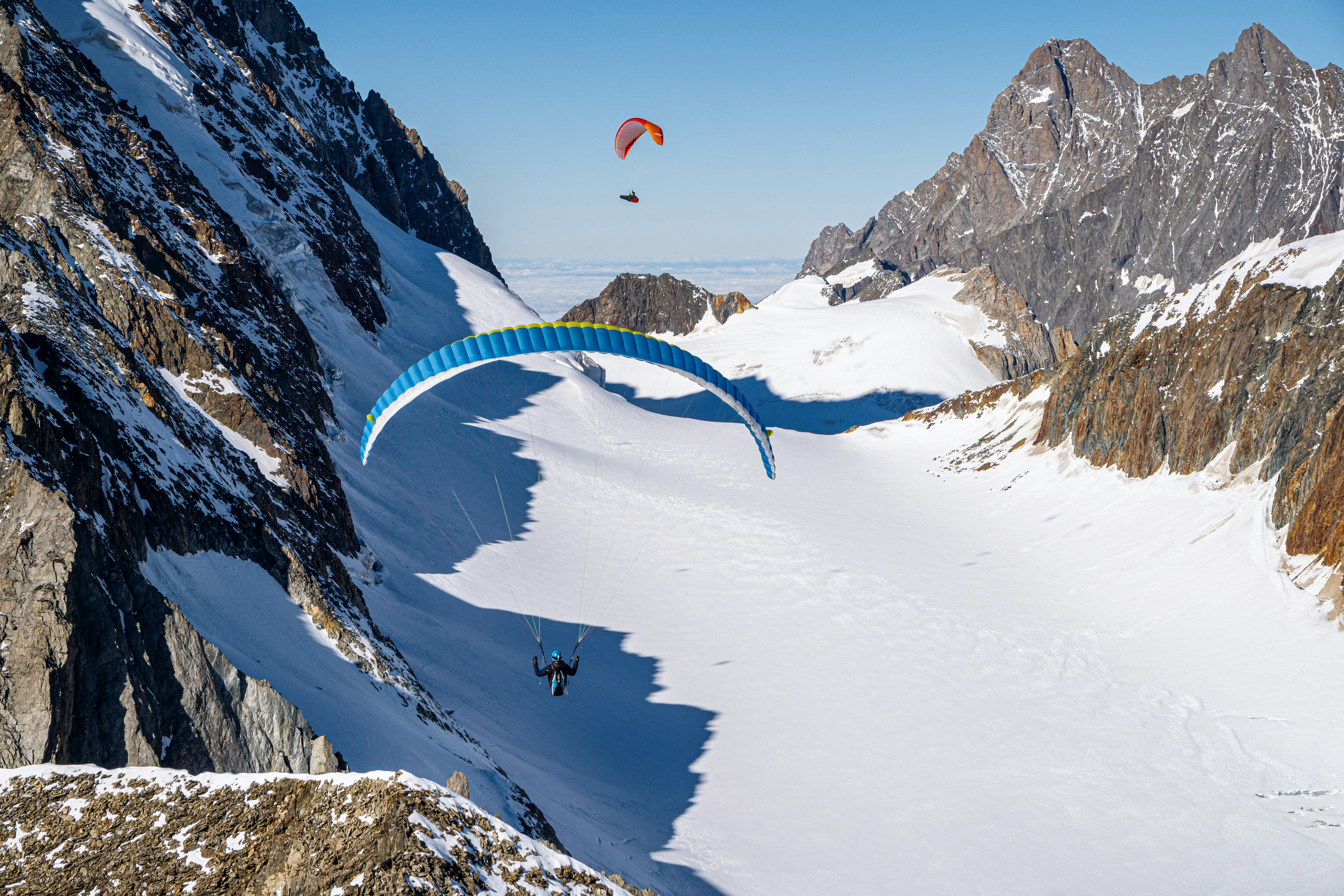 Blue Wing Carves a Glacier Bowl: Paragliders Above Jagged Peaks