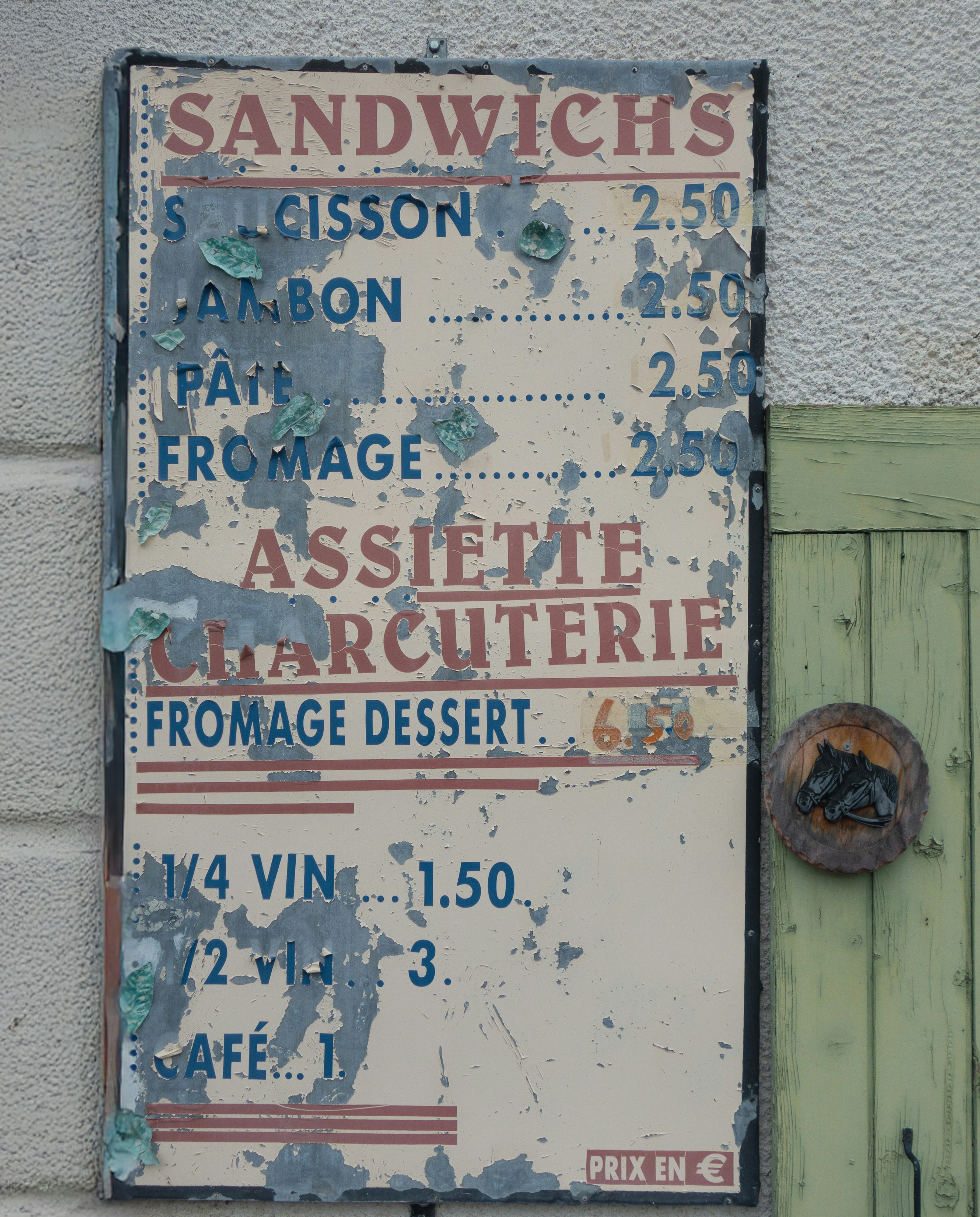 Sur ce chemin, l’homme ne conquiert rien. Il écoute. Il marche entre les pierres et les nuages, là où Stevenson jadis chercha le silence et la vérité. Chaque pas est une mémoire, chaque paysage une page ouverte. Ce n’est pas la France qu’on traverse, mais un monde en miniature — fait de lumière, de solitude, et de rencontres. | Old weathered menu board with food and drink items