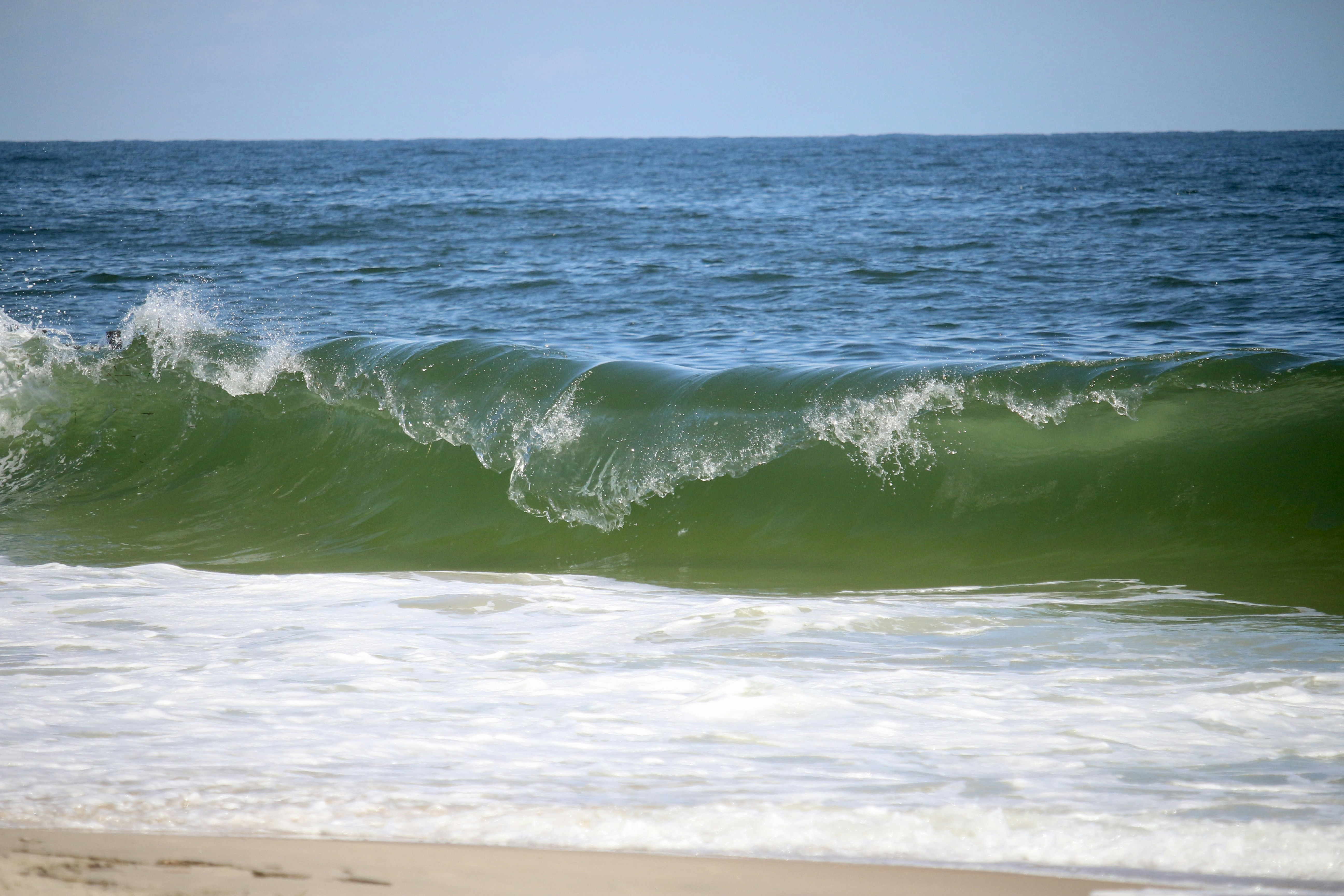 Emerald Lip: Framed Crest Over a Quiet Beach