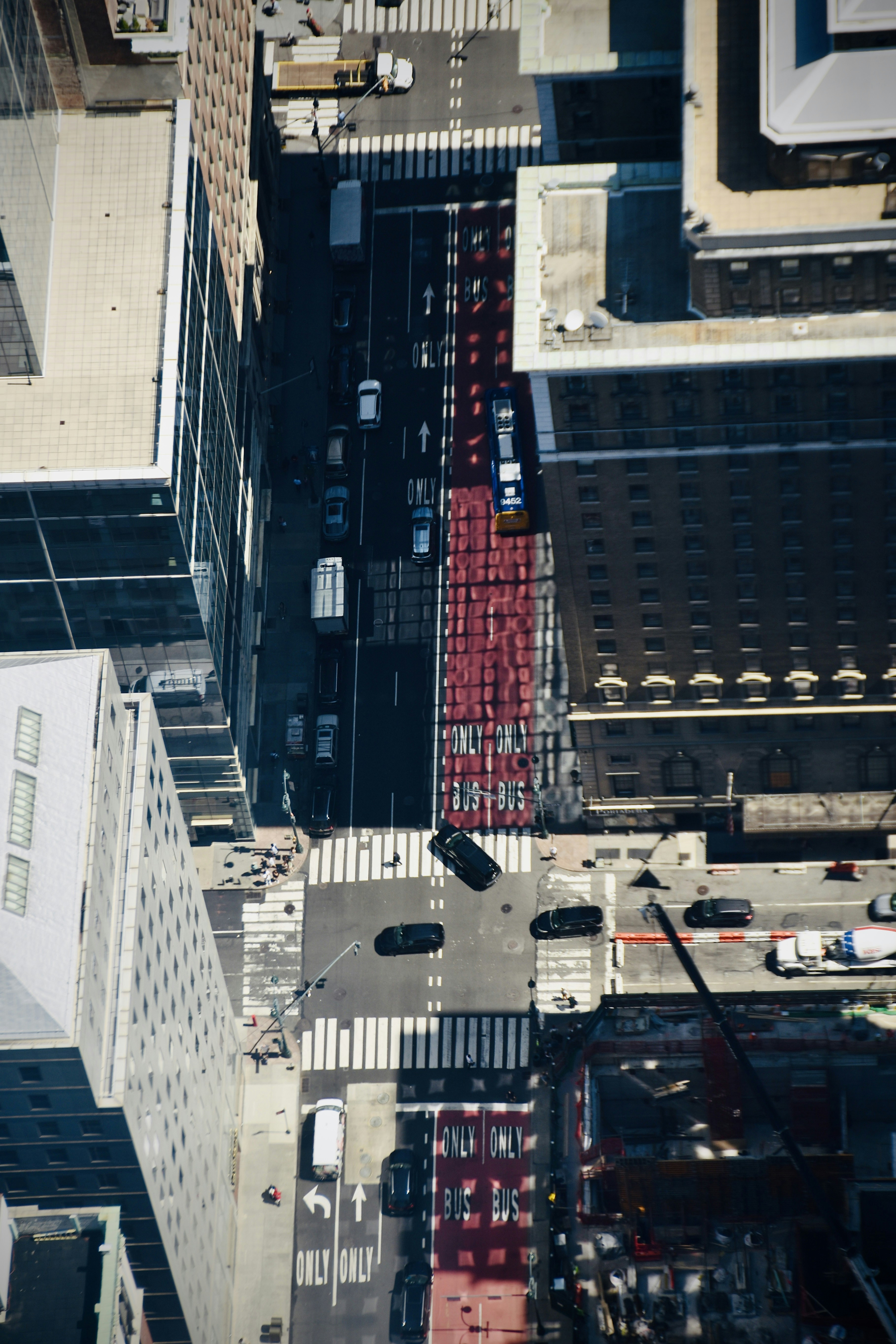 Aerial view of a bustling city intersection showcasing a dedicated bus lane and a mix of vehicles navigating the urban landscape.