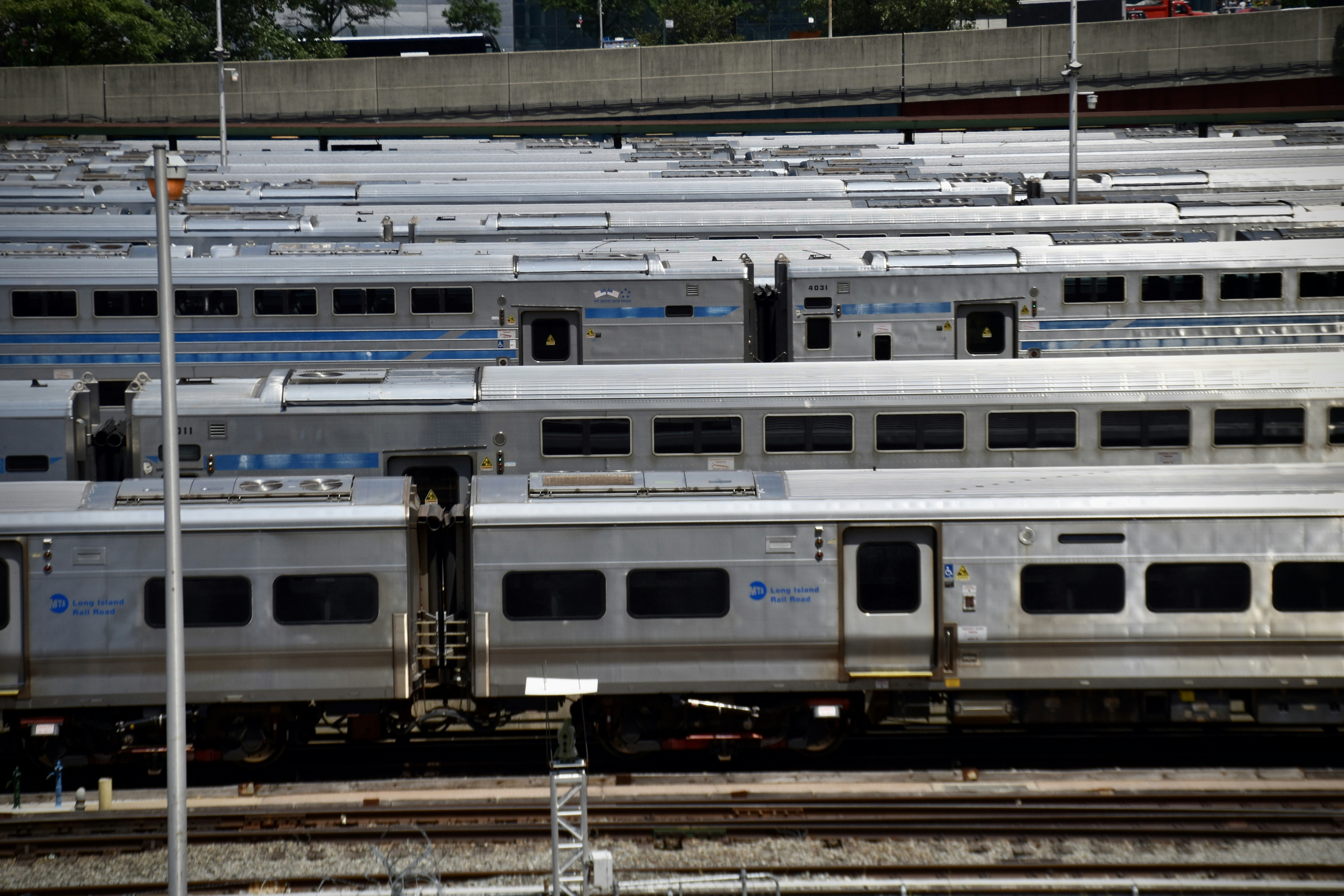 MTA depot at Hudson yards. This are shall be covered for additional buildings to be erected on top of it. | Rows of silver commuter trains parked on tracks.