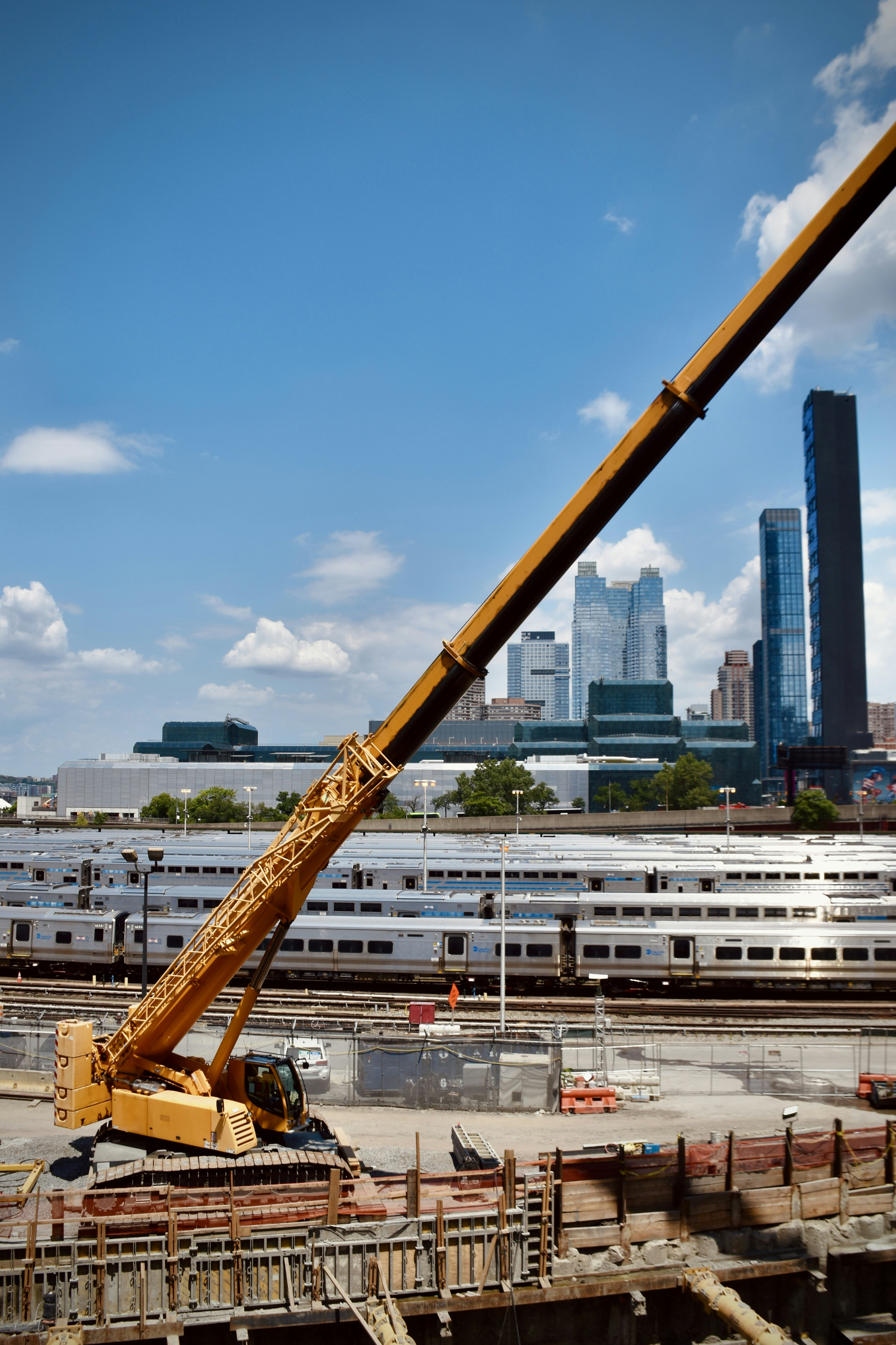 Diagonal Crane Framing a Waterfront Rail Yard Against a City Skyline