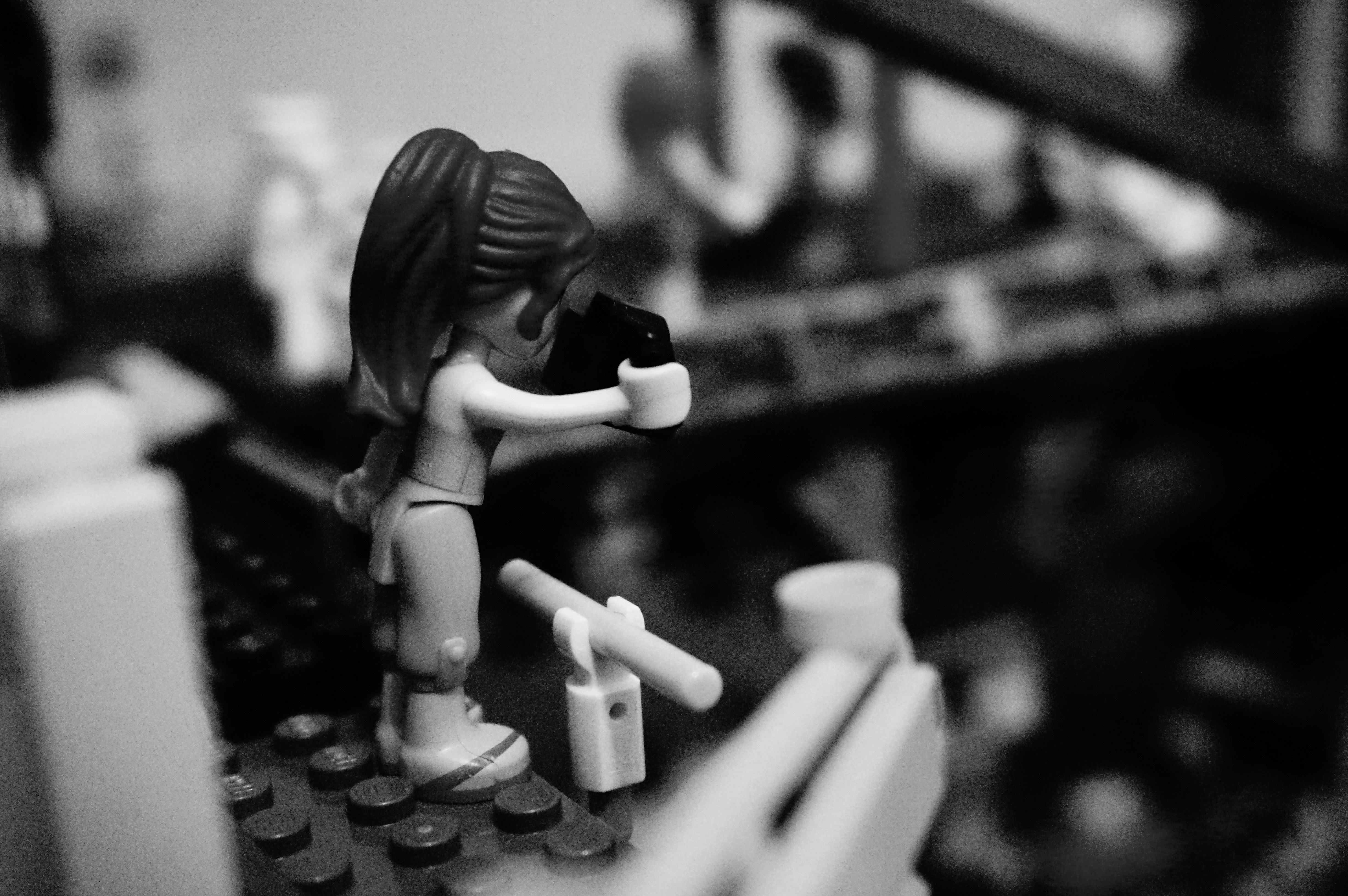 A lego figure holding a cup with a rifle nearby