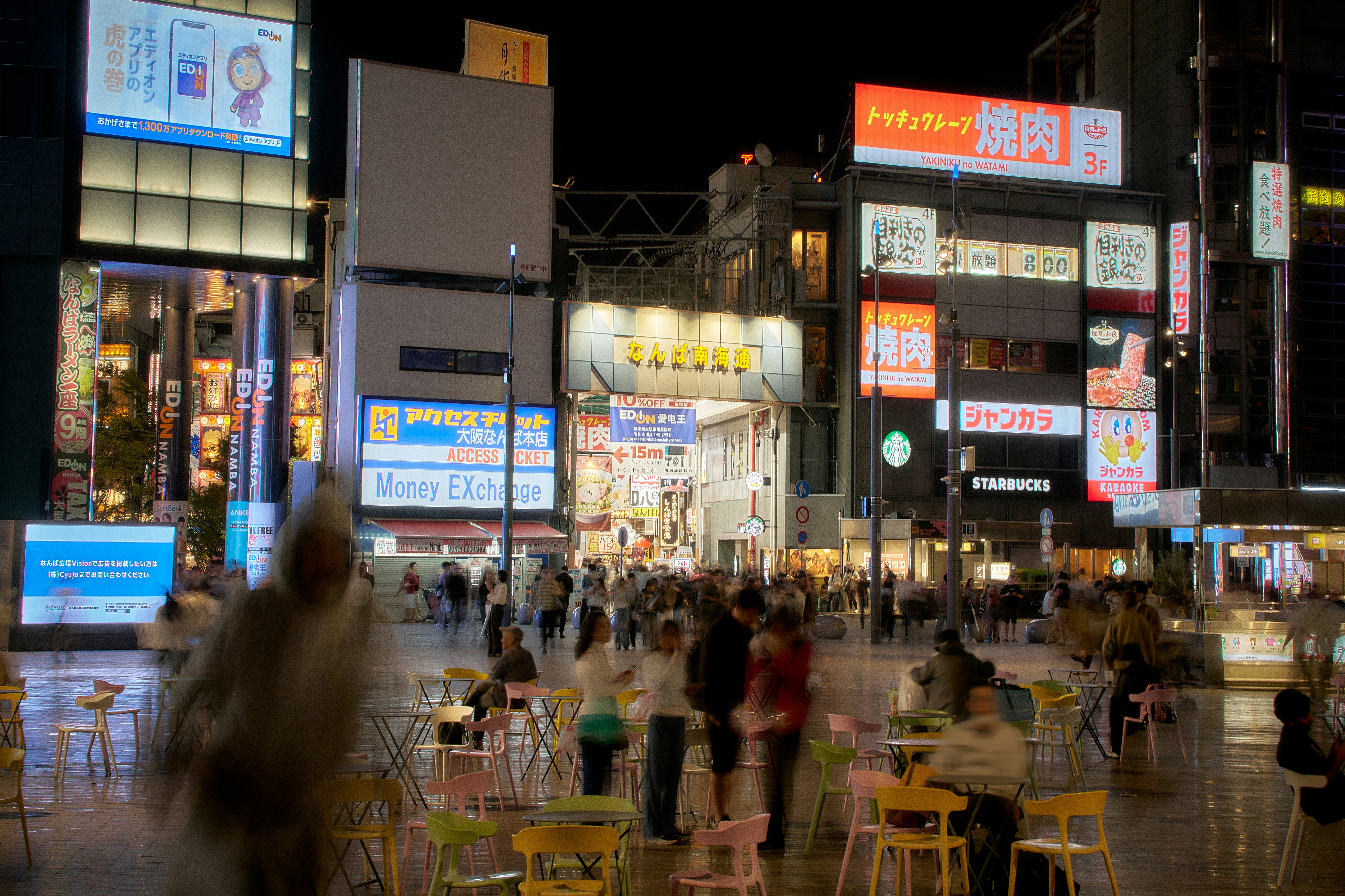Busy city street at night with glowing signs