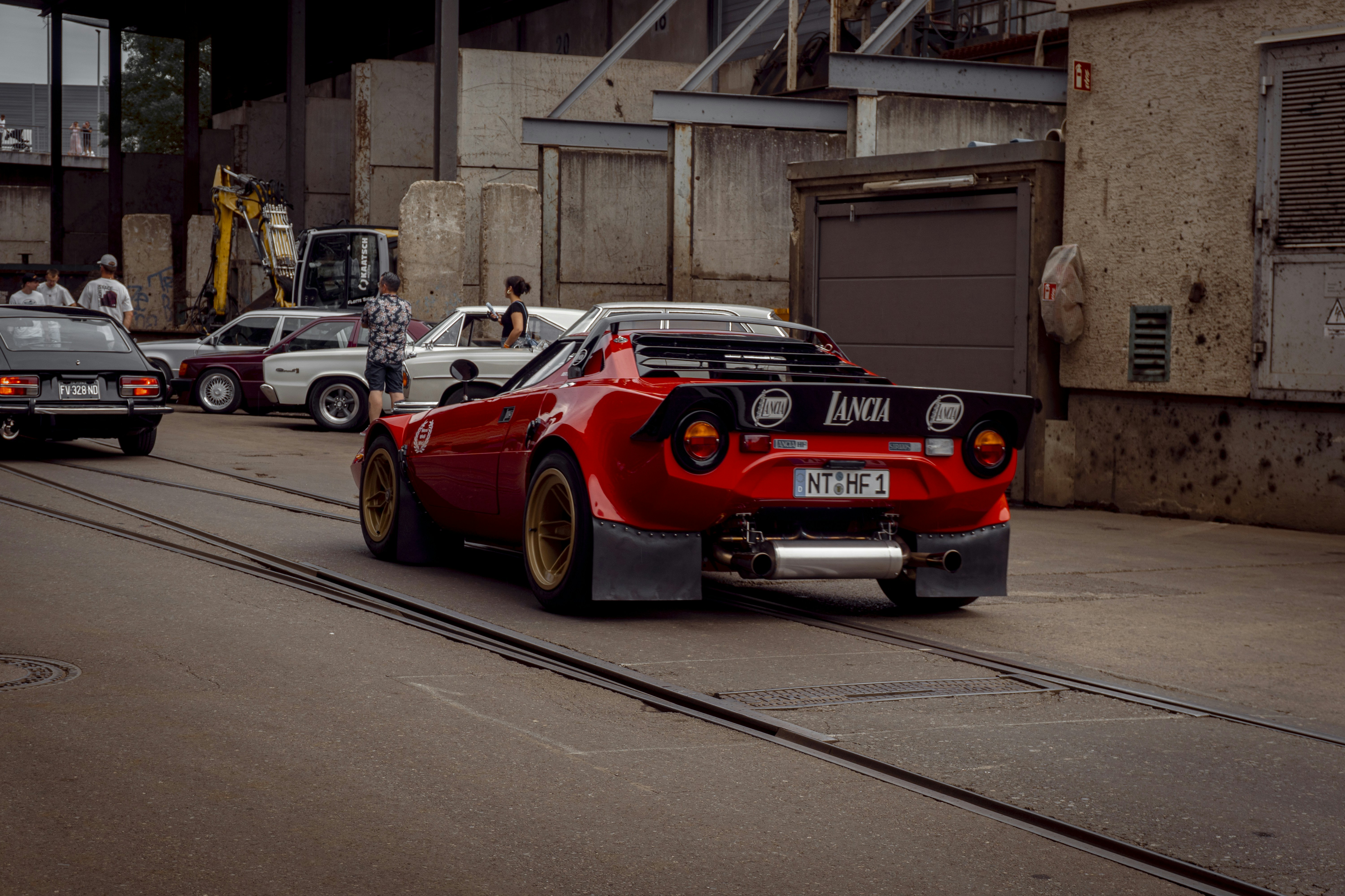 Red lancia stratos rally car driving on street