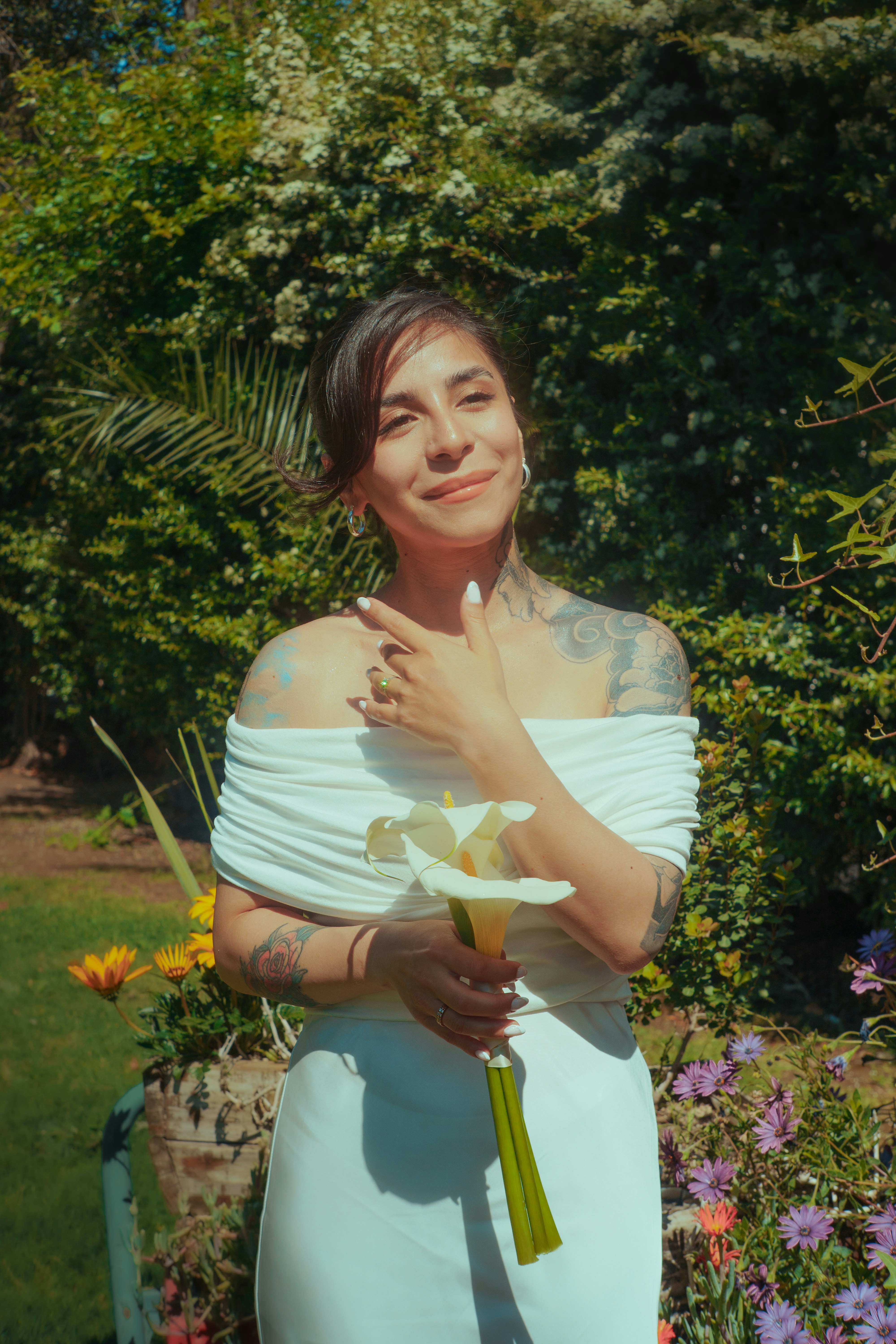 Bride holding a white calla lily bouquet outdoors.