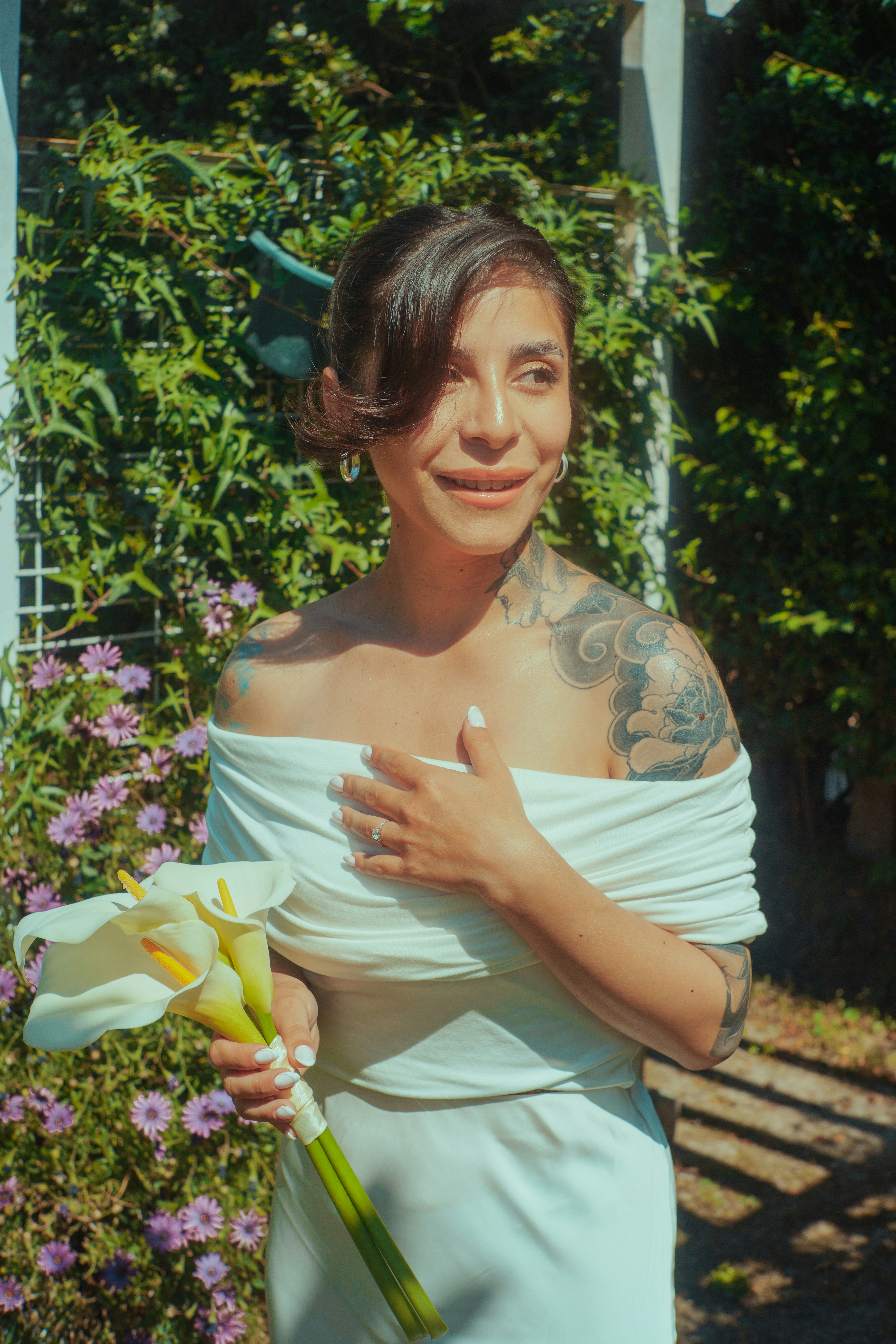 Bride in white dress holding calla lilies