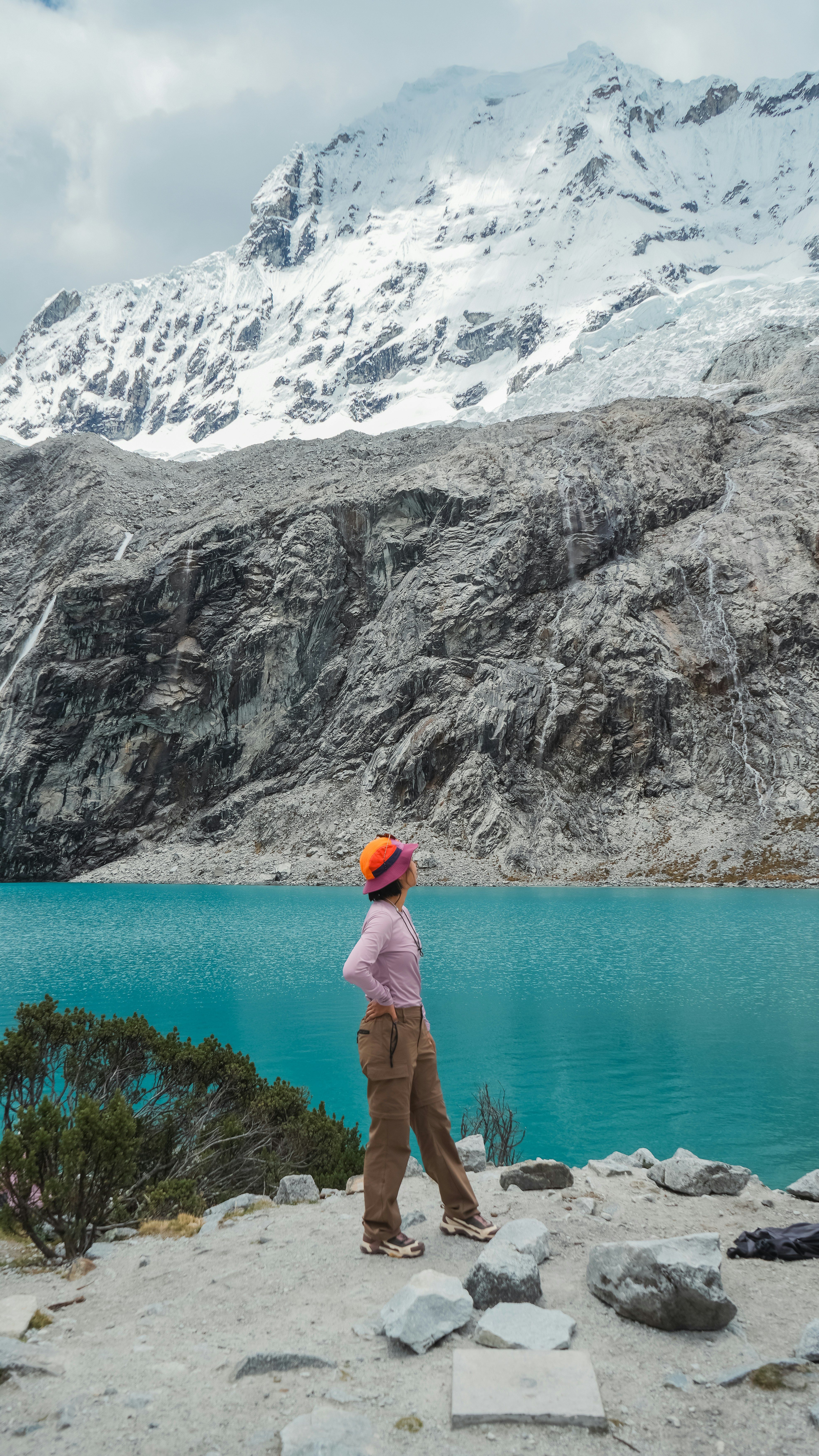 Laguna 69 An adventure that will literally leave you breathless. A 6-hour hike, 7 kilometers one way and 7 back, 14 kilometers in total. Without a doubt, Huaraz is the city of trekking | Woman looking at a turquoise lake and snowy mountains.