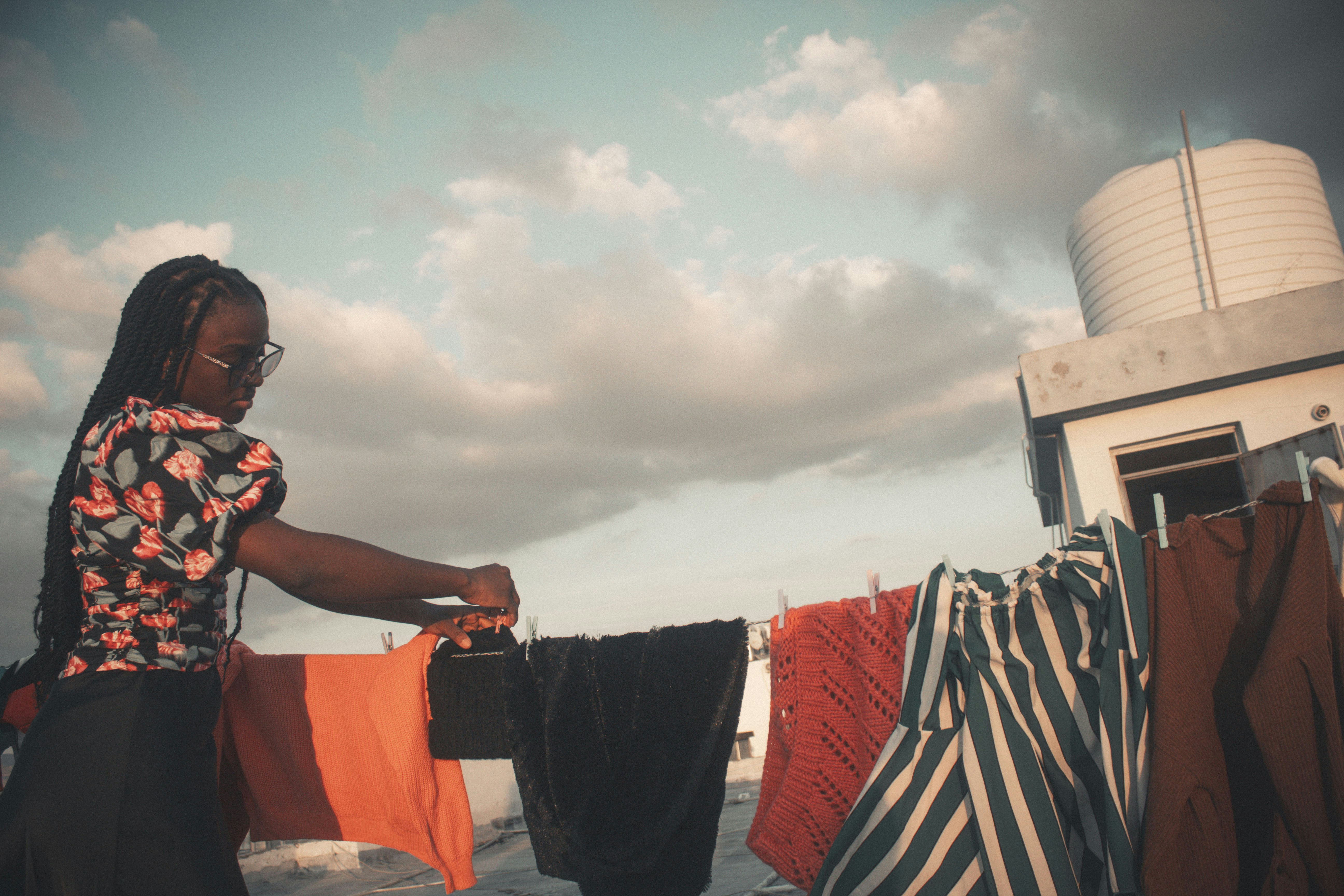 Woman hanging clothes on a clothesline outdoors.