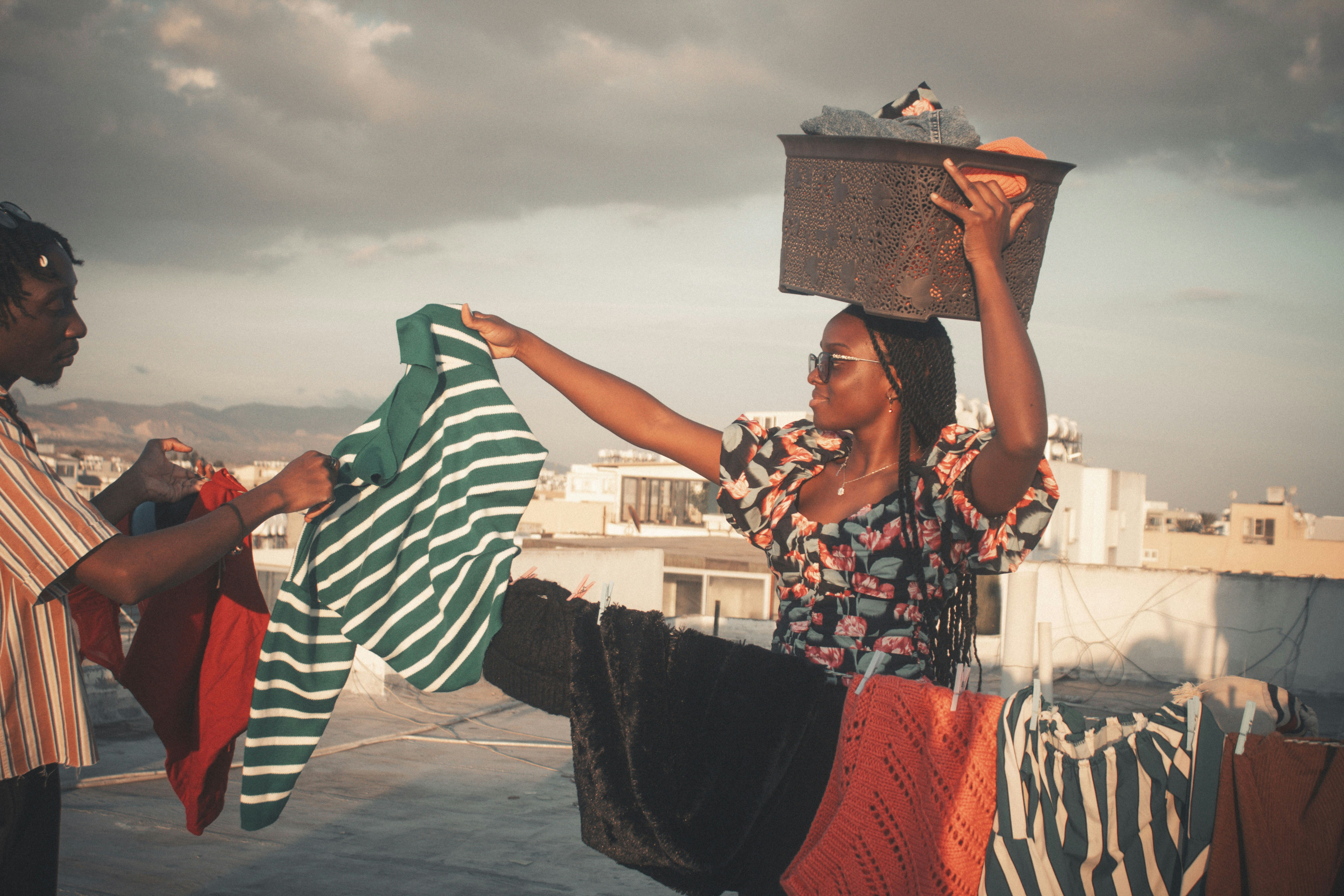Two women hanging laundry on a rooftop.
