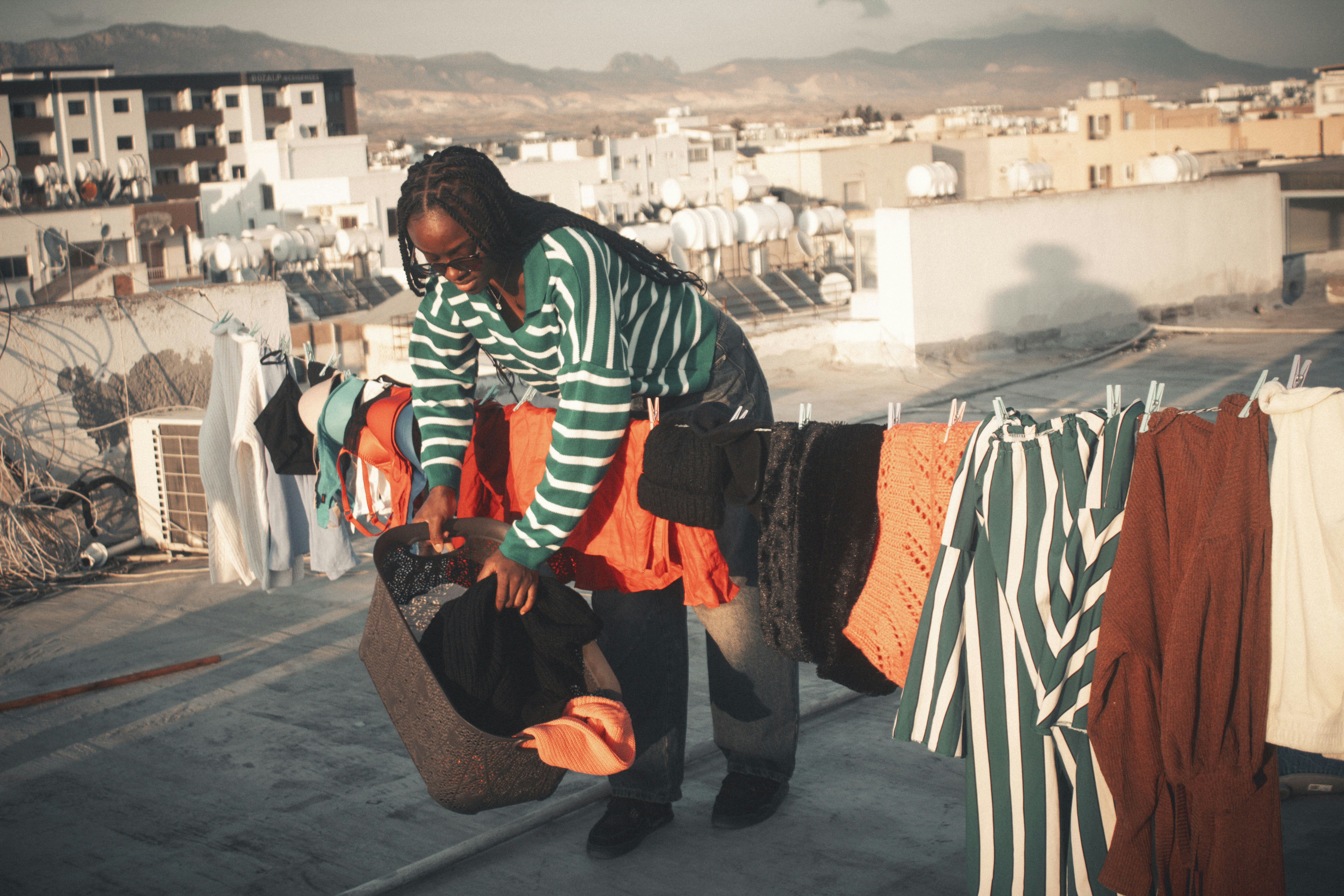 Woman hanging laundry on a rooftop clothesline.