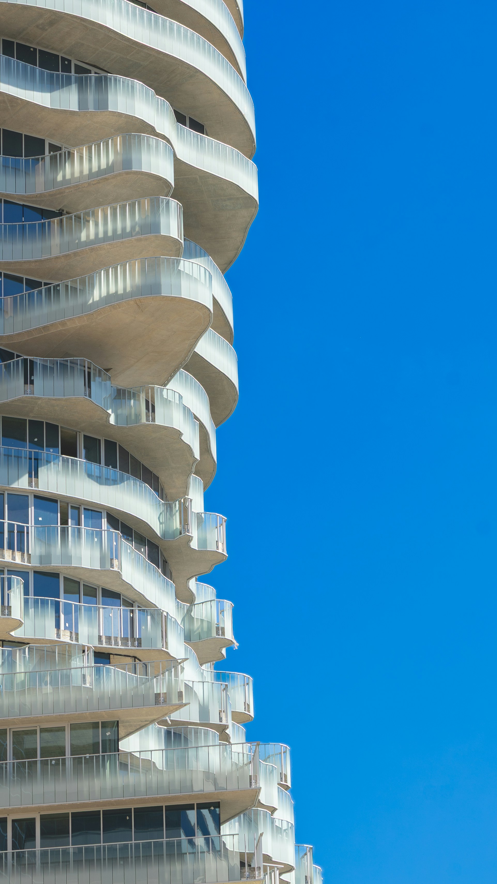 Modern building with curved balconies against blue sky