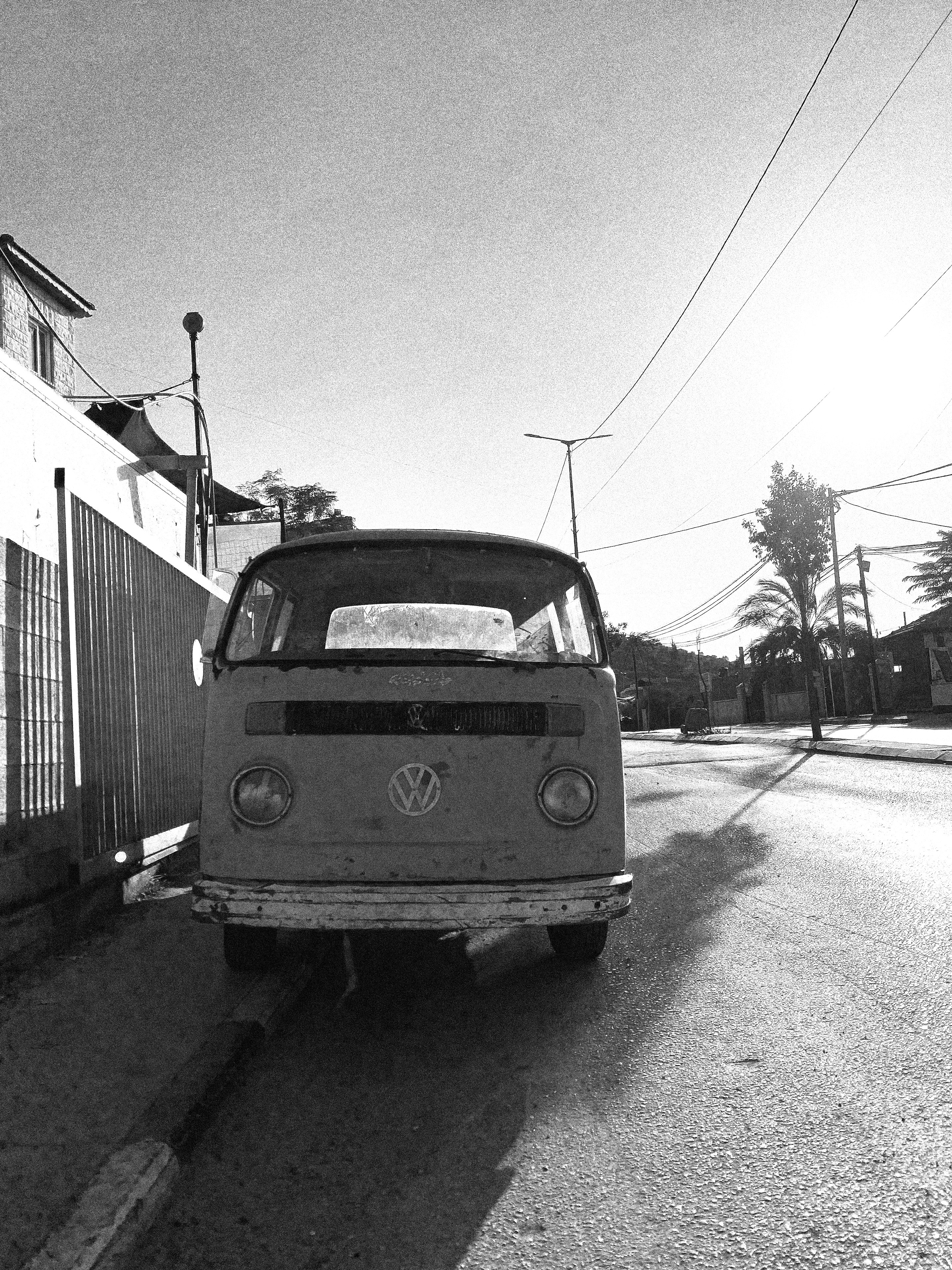 Vintage volkswagen bus parked on a sunny street.
