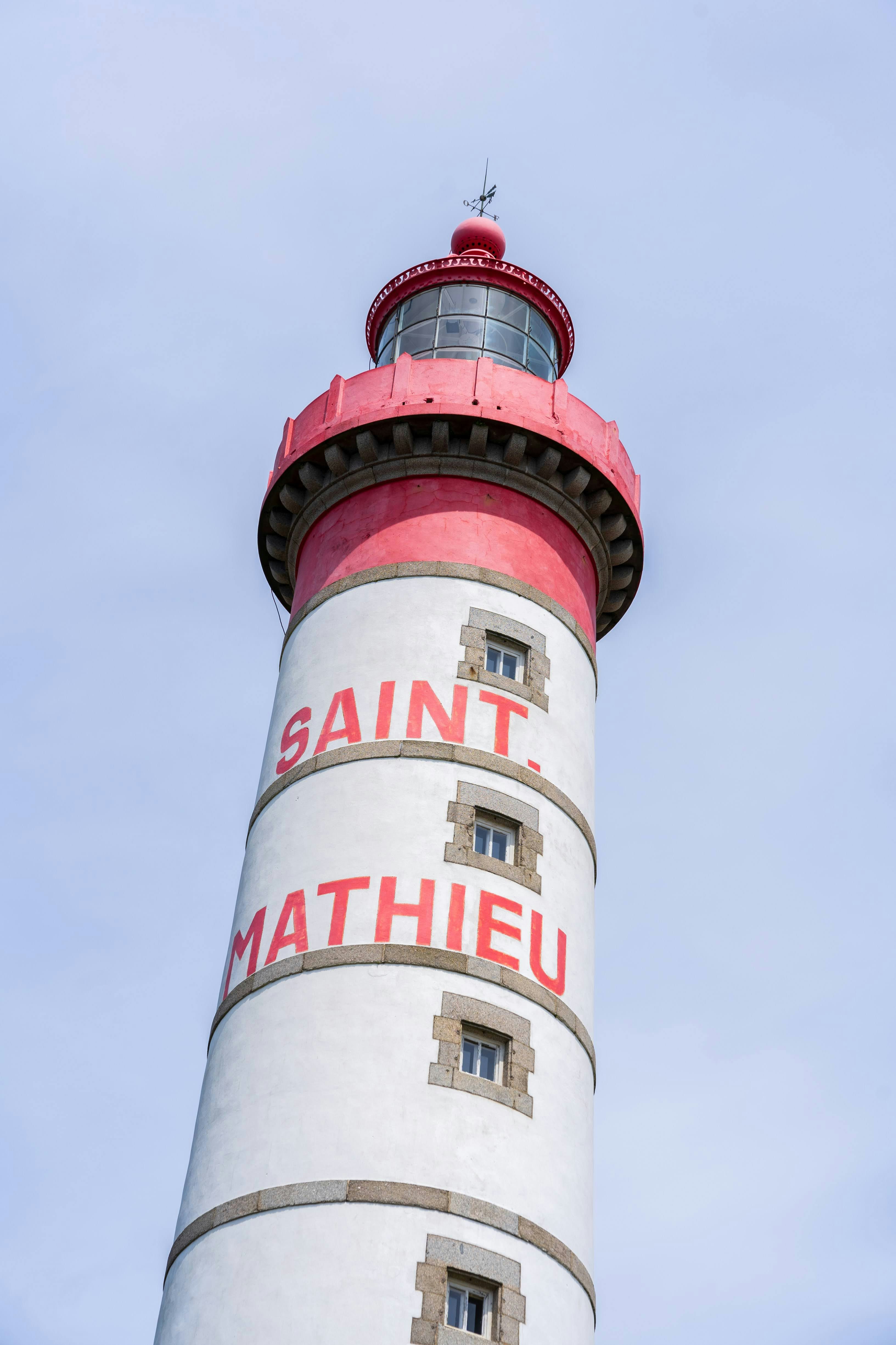 White lighthouse with red top and lettering