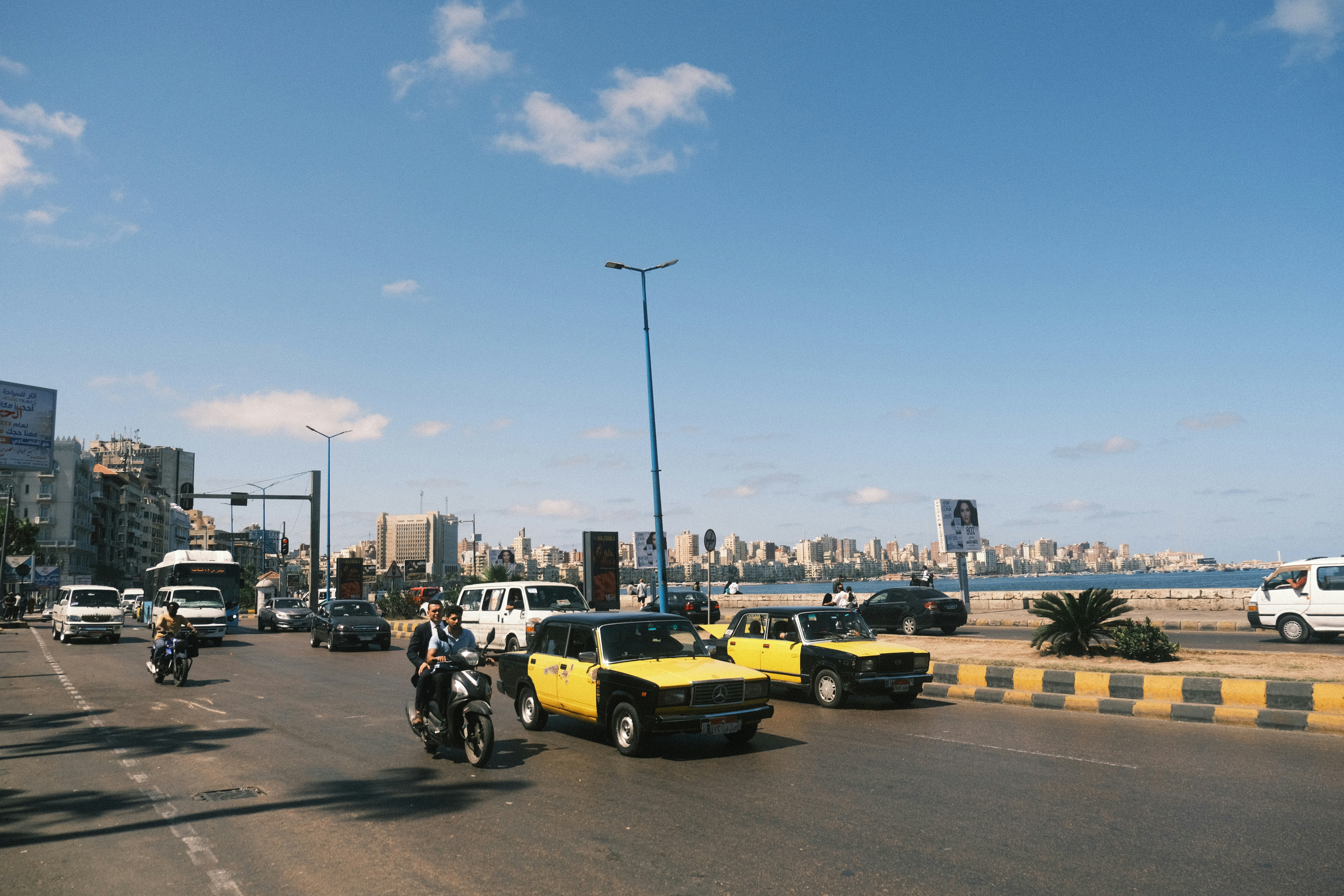 Alexandria coast and street | Cars and motorcycles on a sunny coastal road