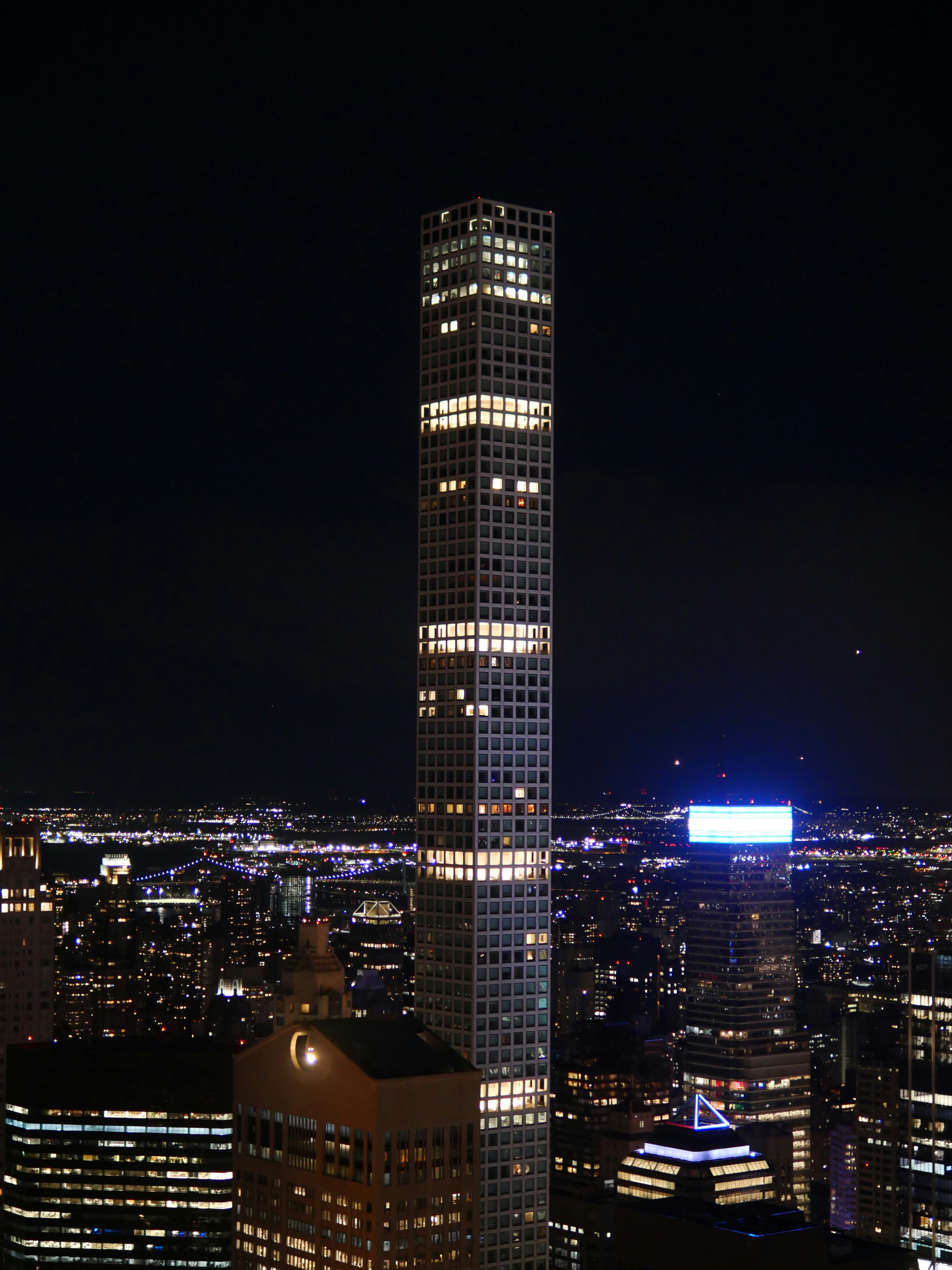 Tall skyscraper illuminated at night with city lights