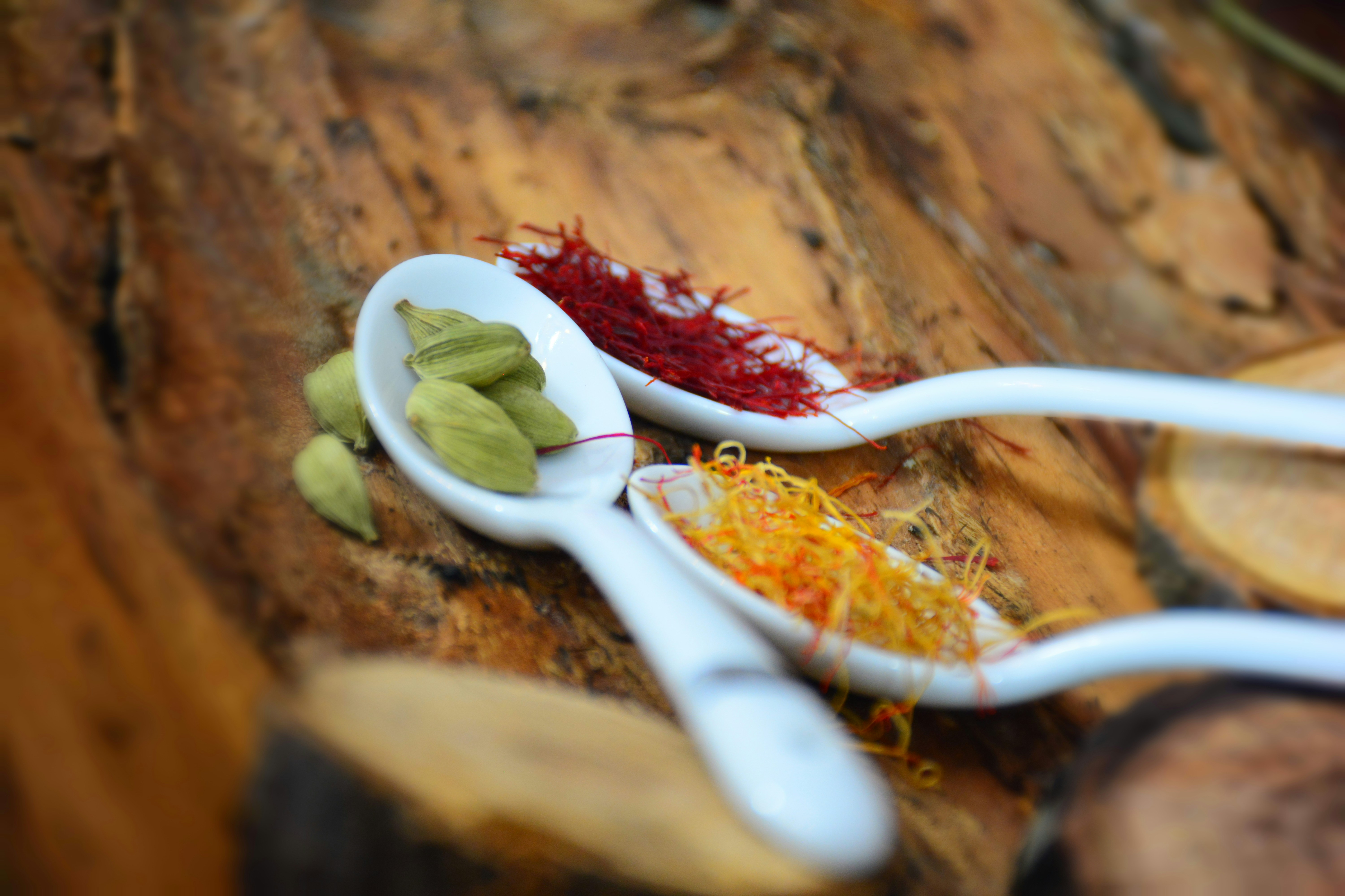 Spice Trio: Saffron, Cardamom, and Citrus in a Close-Up on Wood