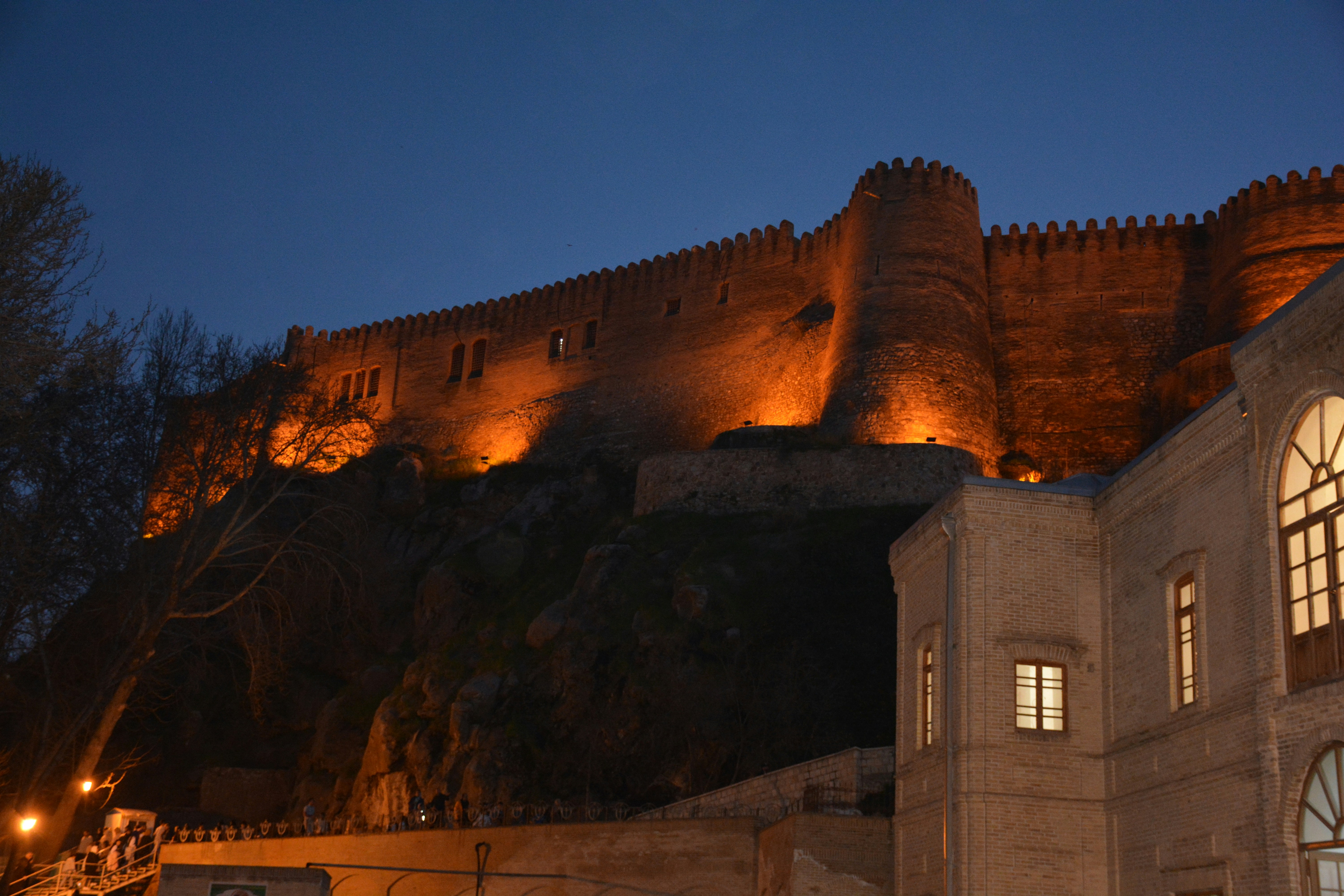 Ancient fortress illuminated at night under a dark sky