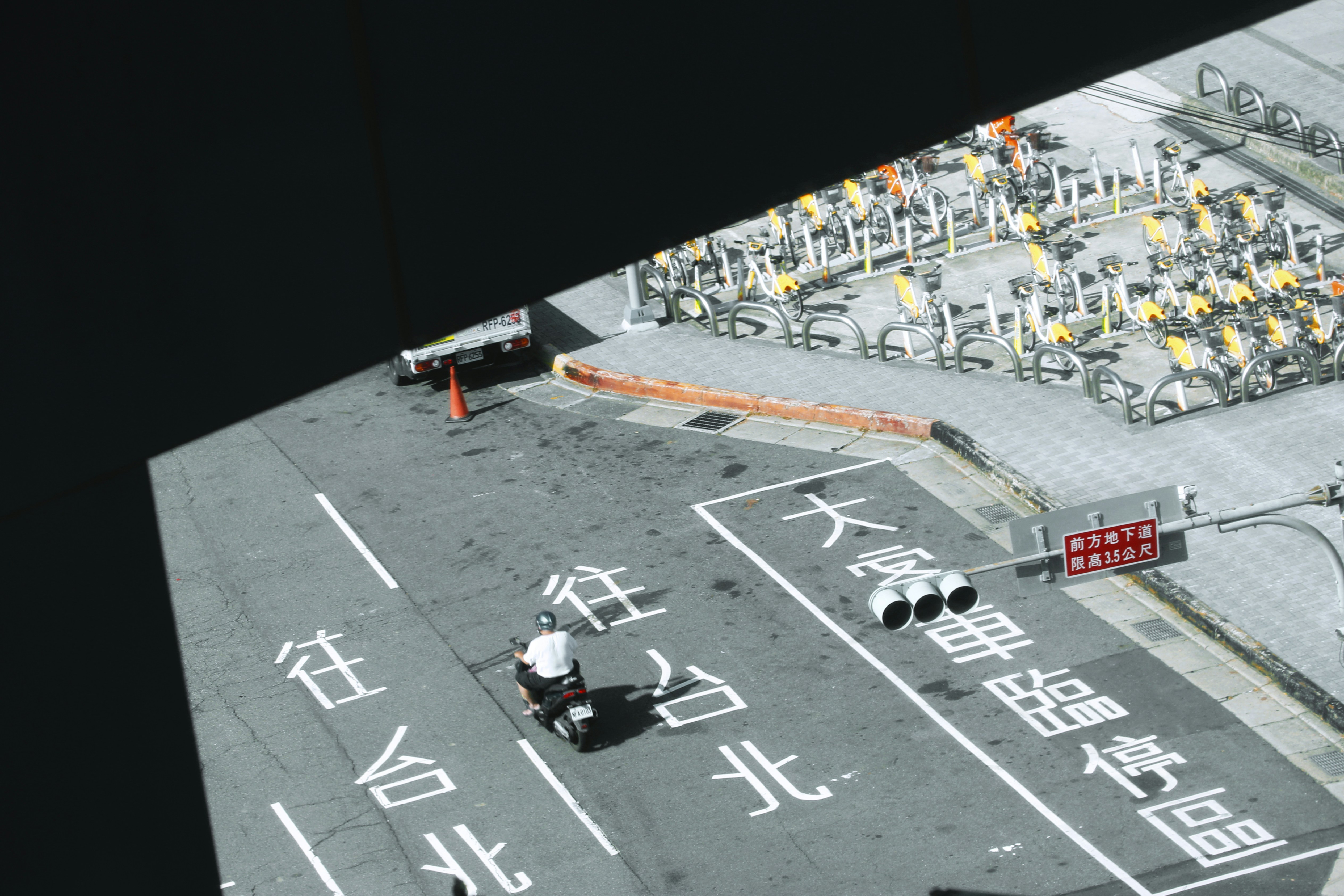 Motorcyclist on street with bike parking area.