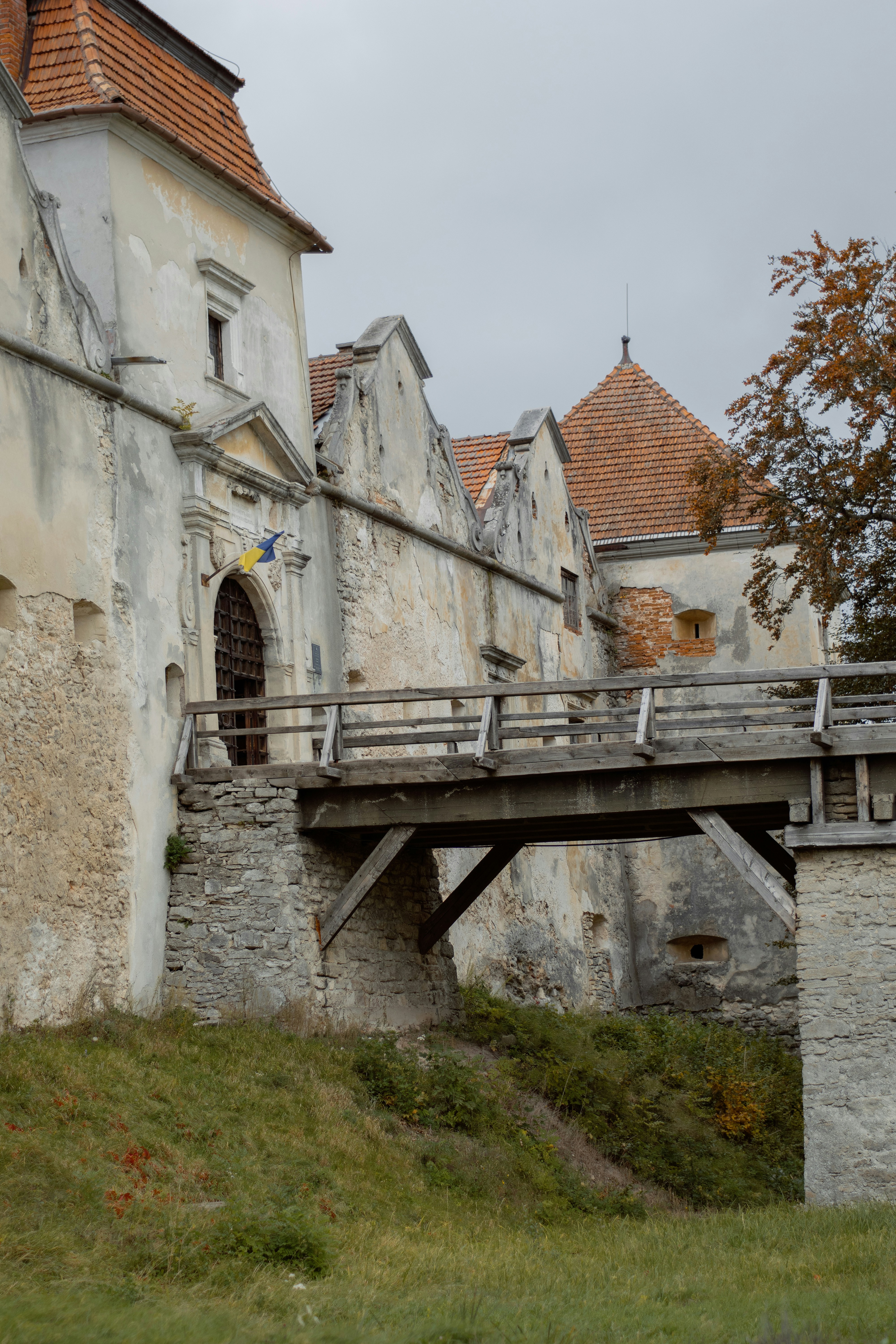 Wooden bridge leading to an old stone castle entrance.