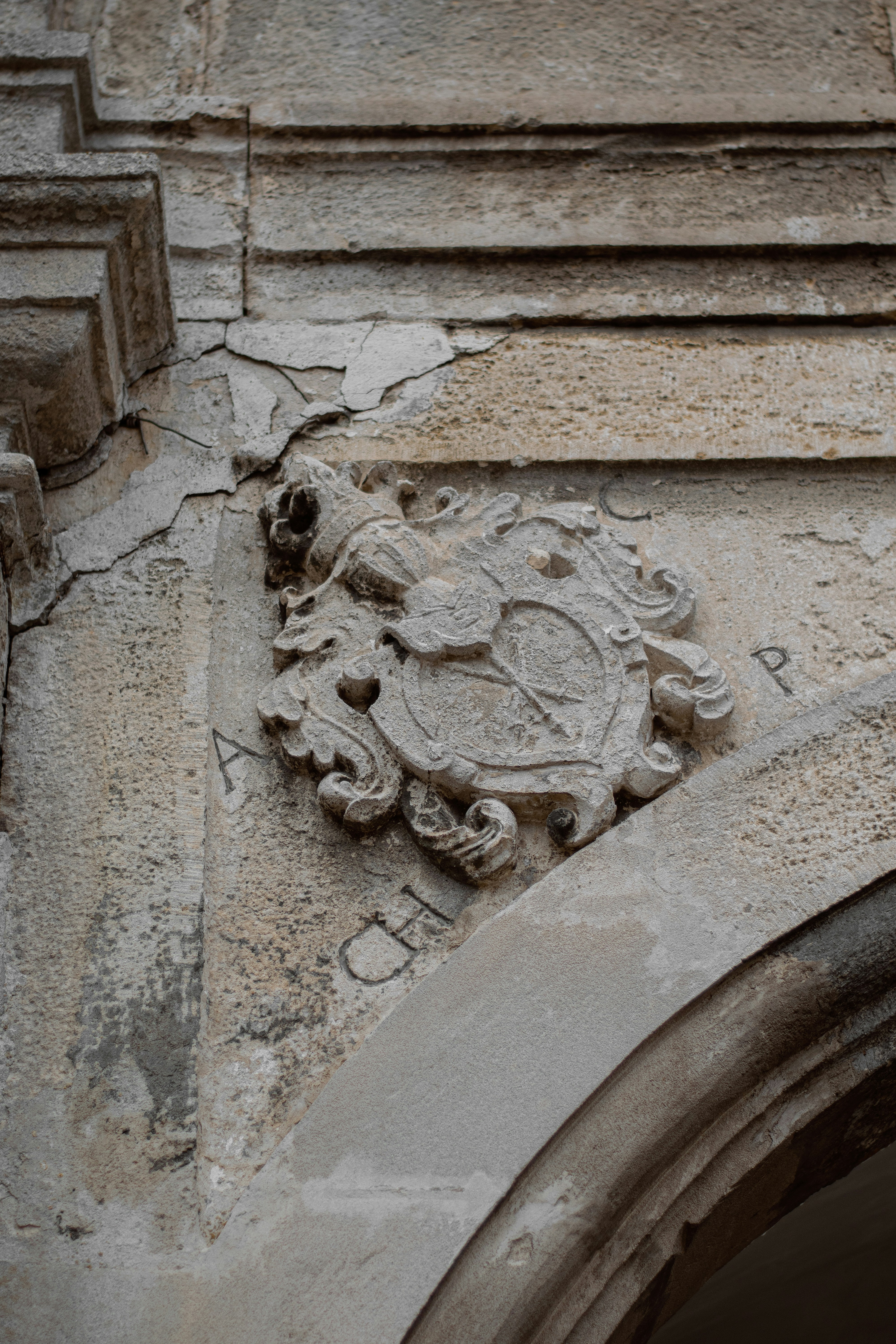 Stone carving of a coat of arms above an archway.