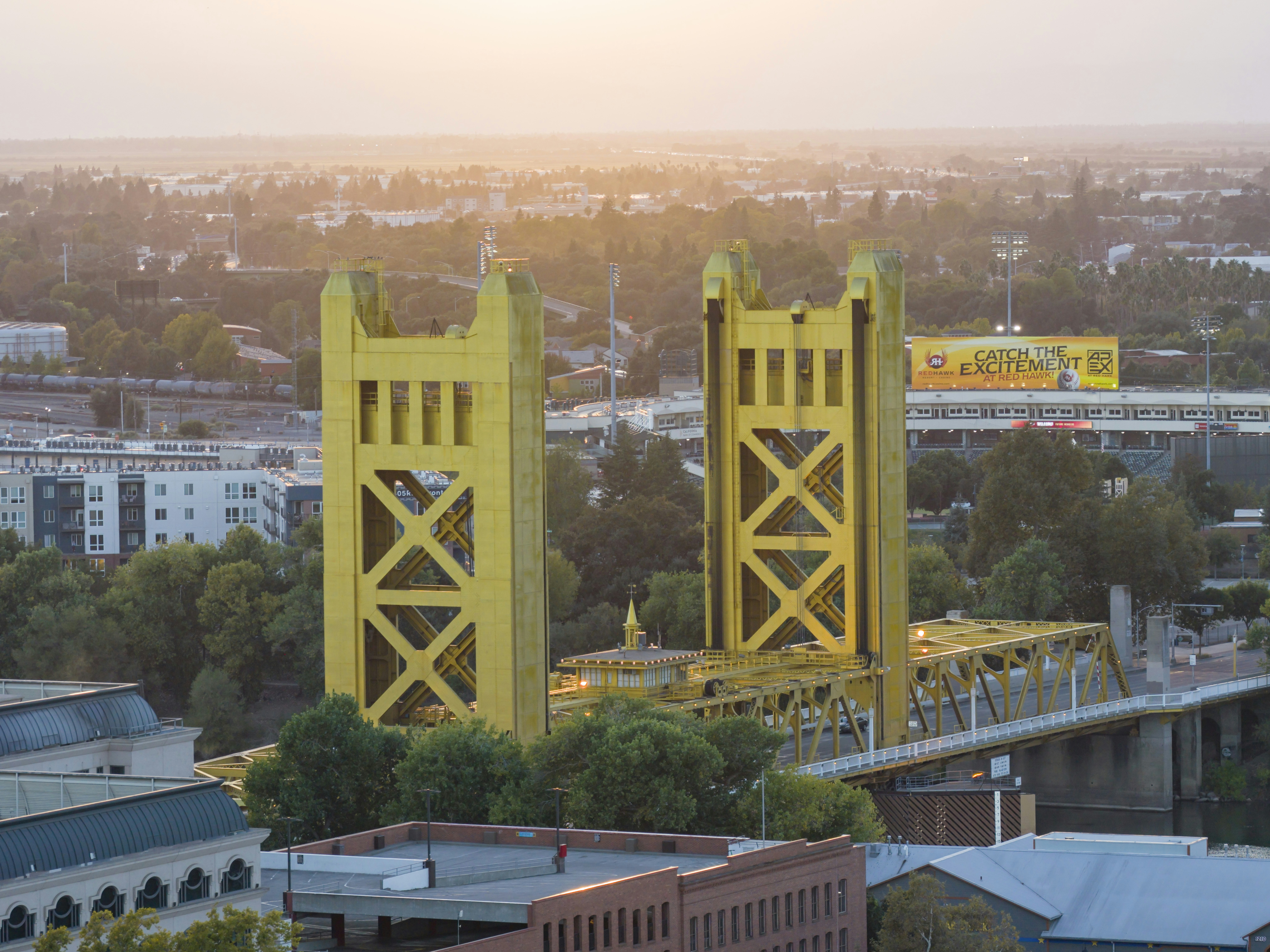 Golden bridge towers against a hazy sunset sky.