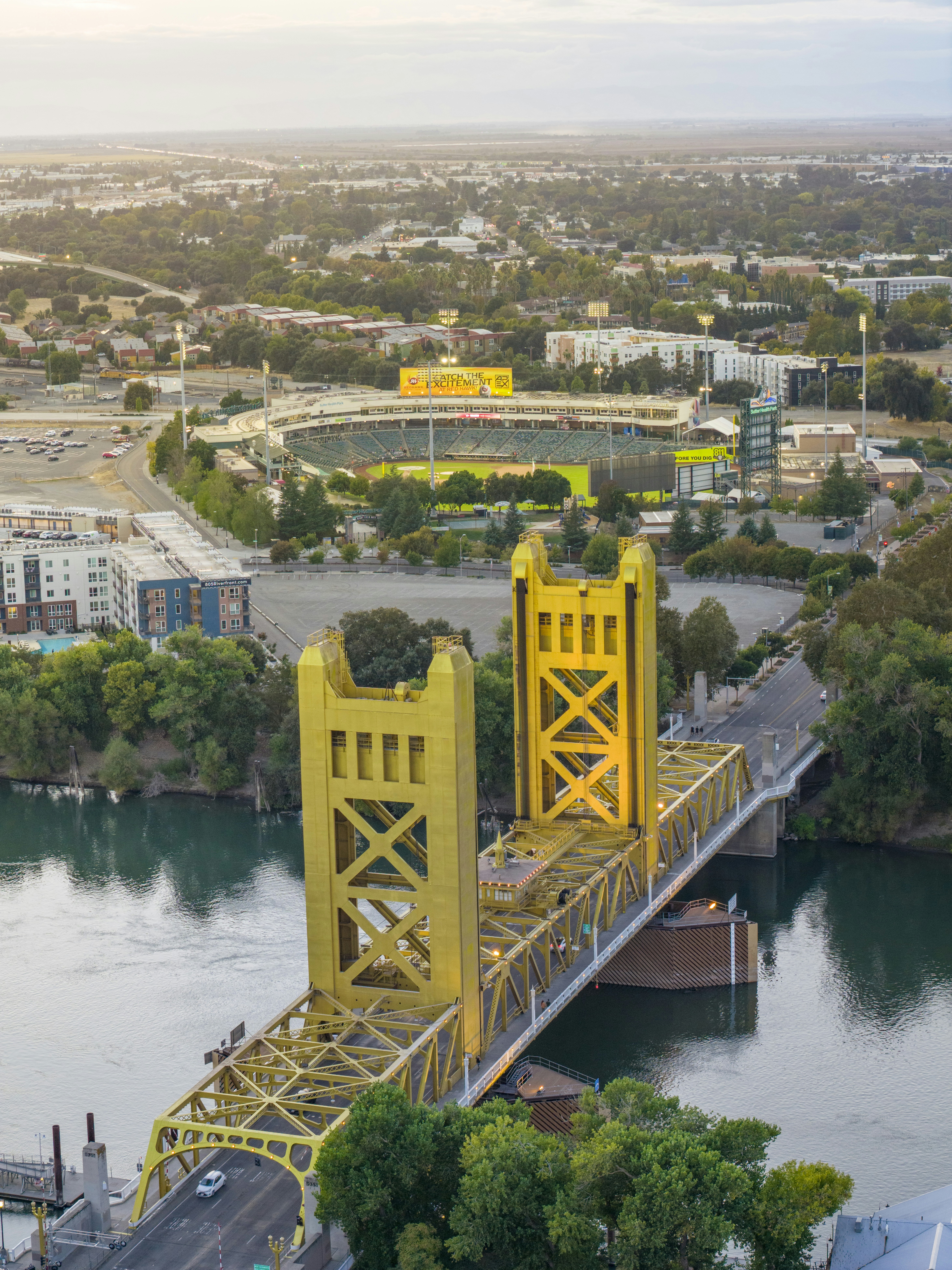 Sunlit Yellow Towers: Aerial Portrait of a Riverside Bridge