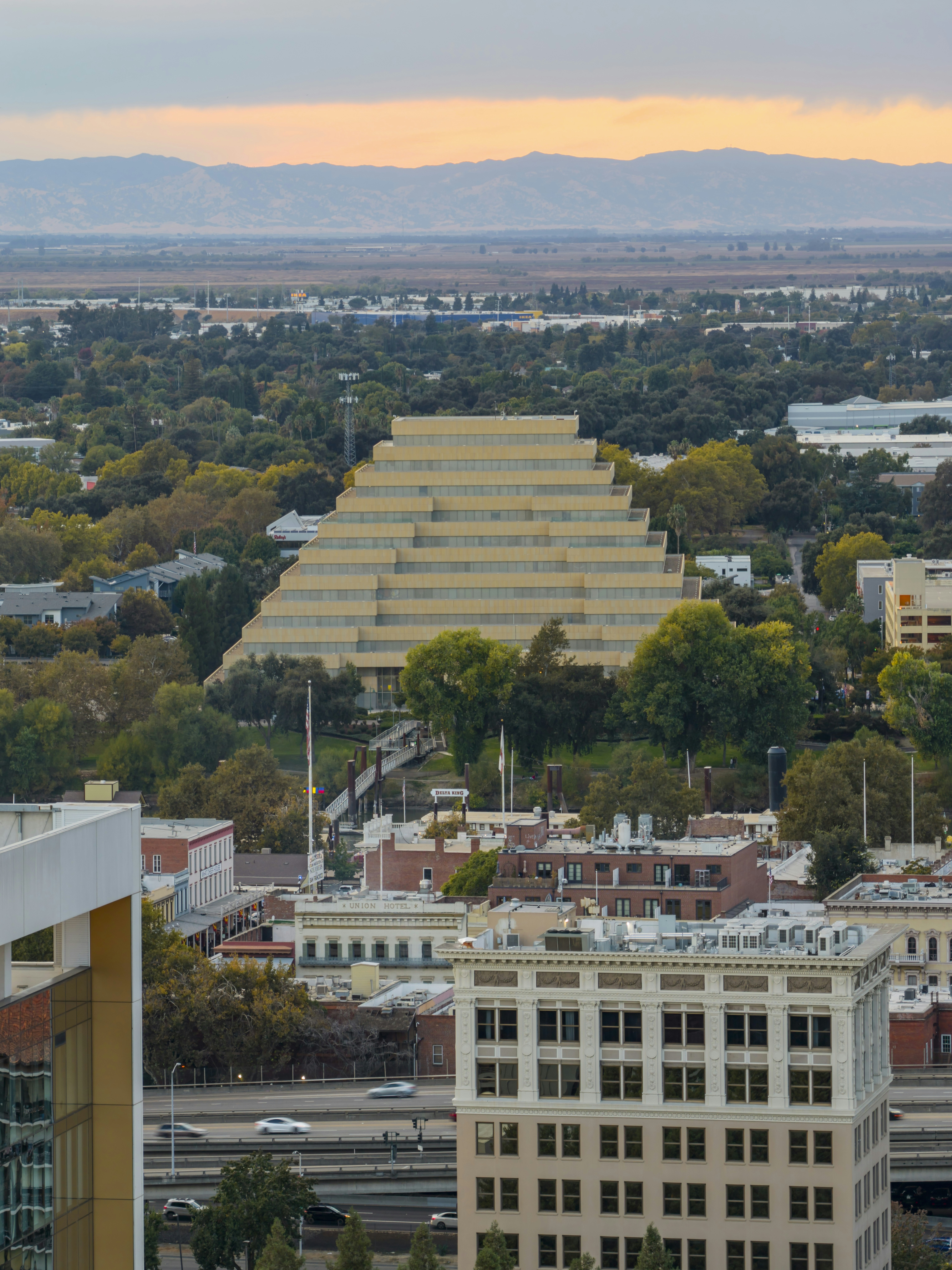 Golden pyramid-shaped building amidst trees and cityscape photo – Free ...