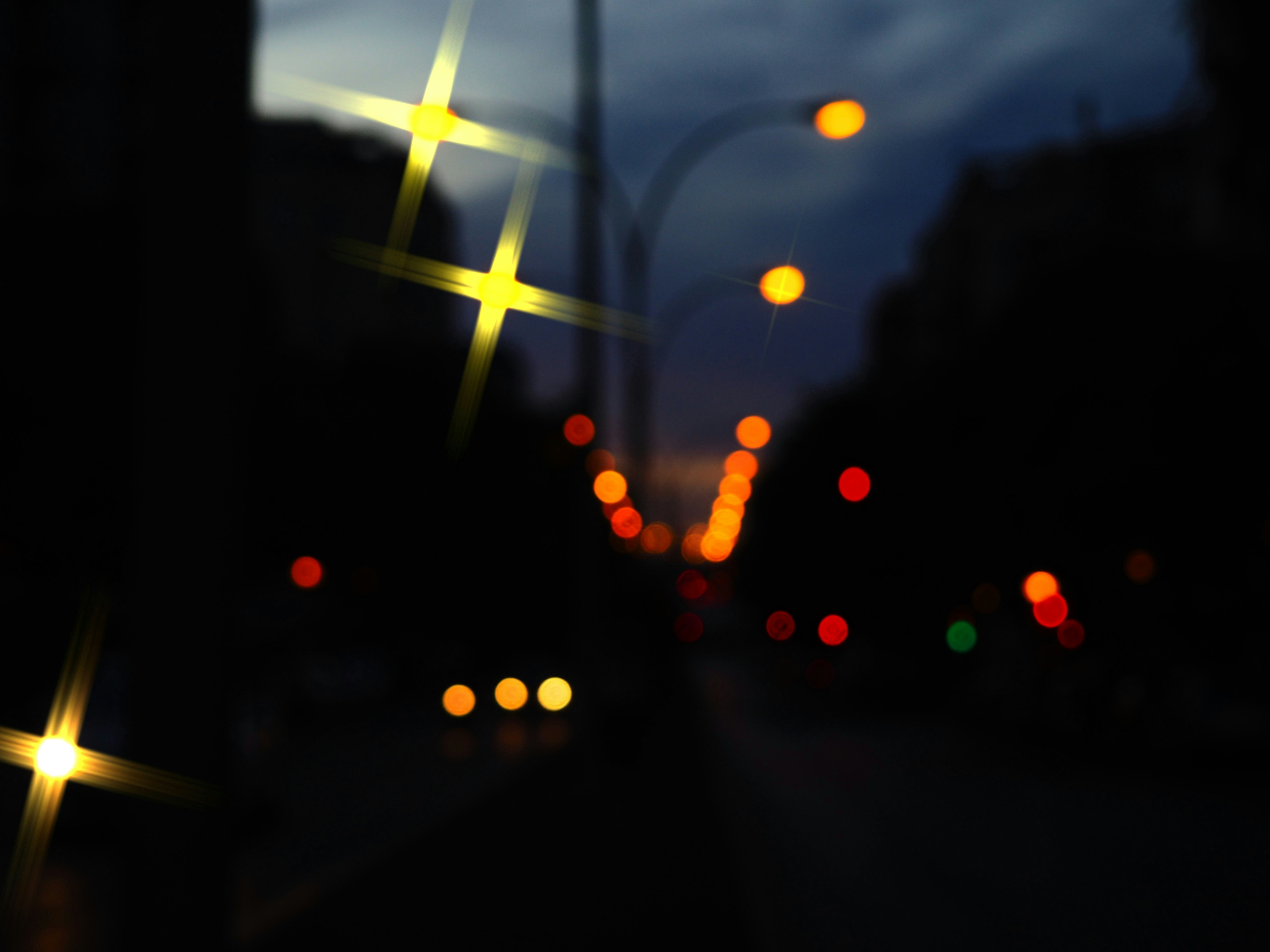 Bokeh star lense effect, city lights, stormy sky, Alicante | Blurred streetlights and bokeh at dusk