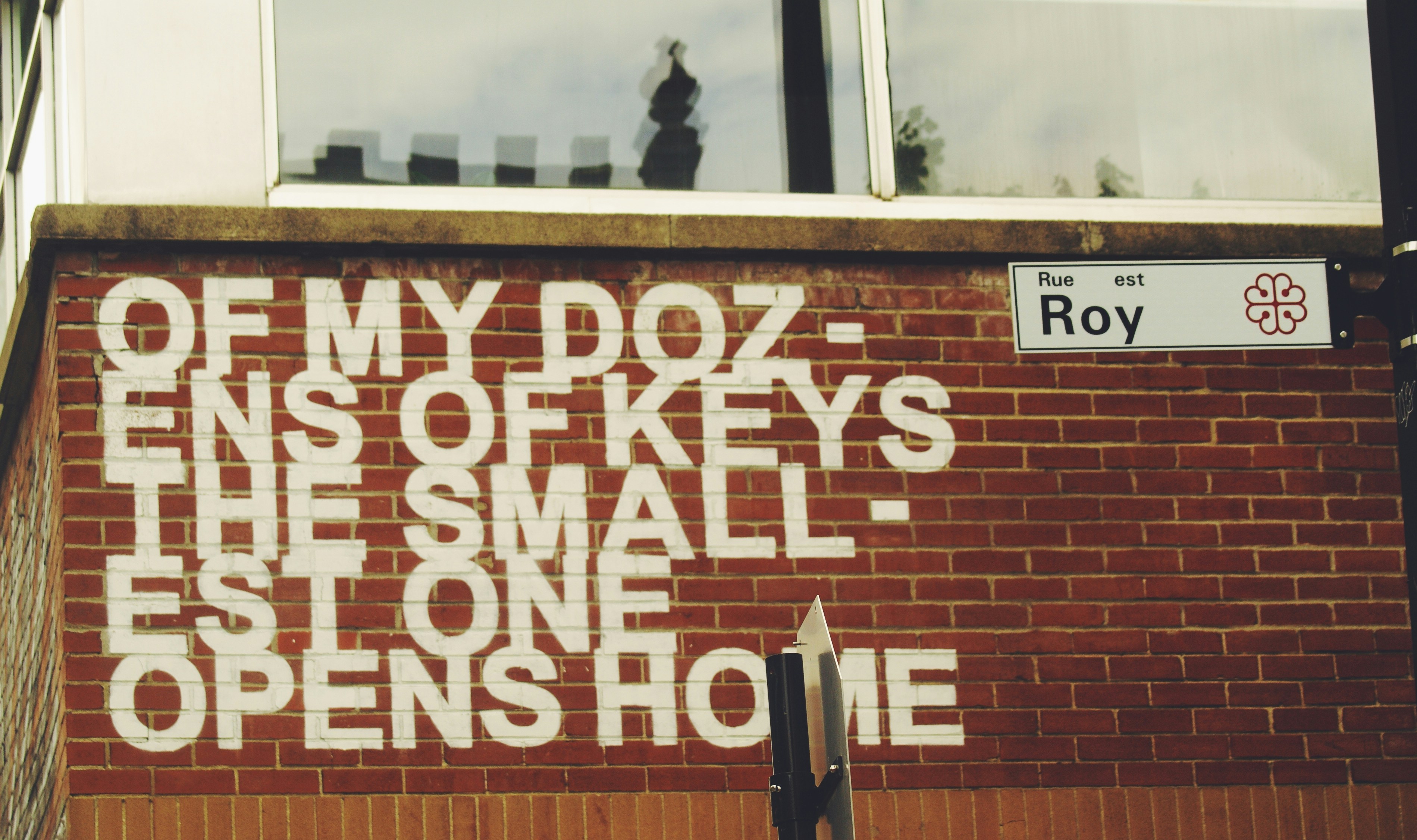 City sign with street sign from Montreal | Text on brick wall with street sign